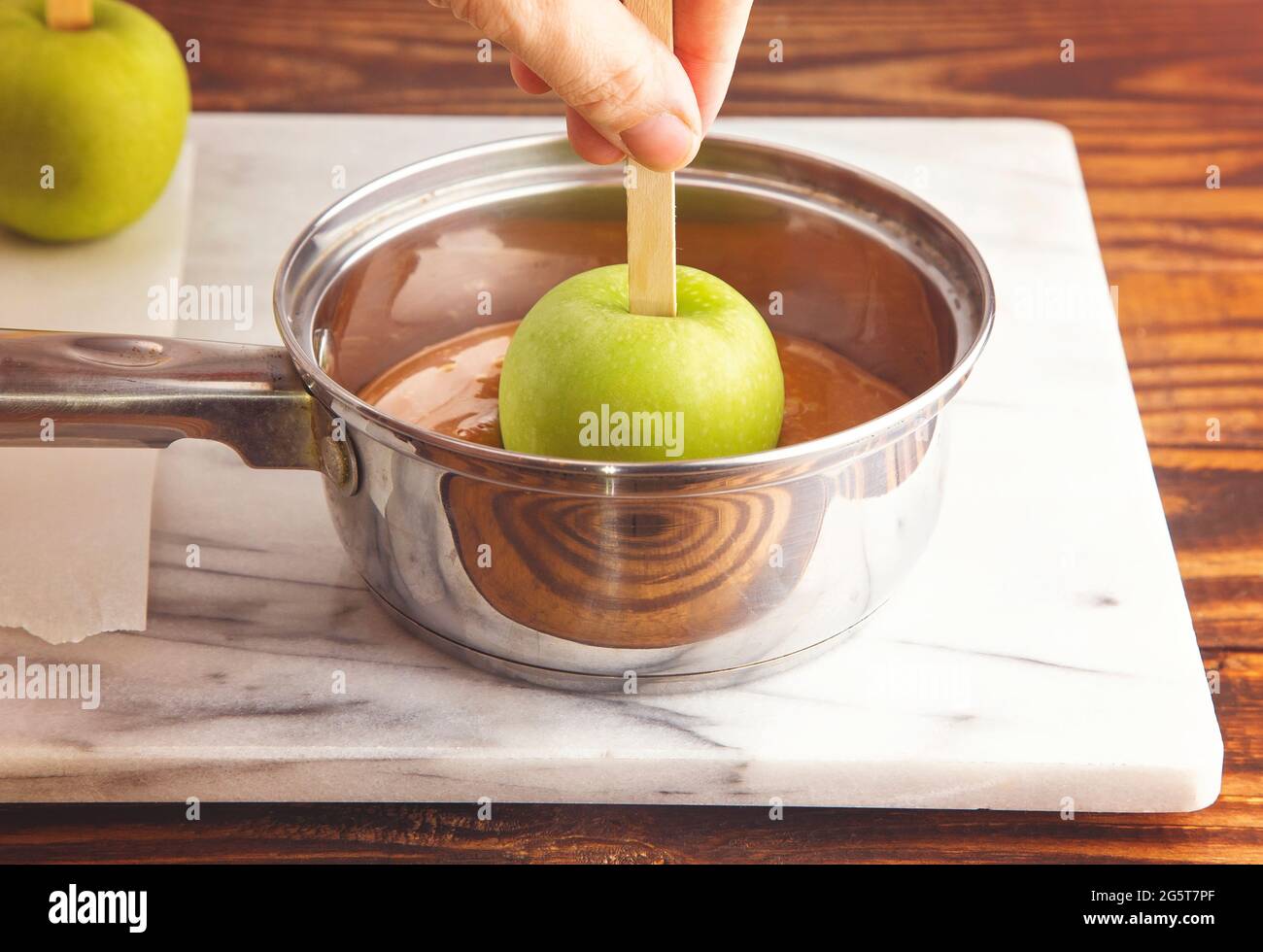 Someone Dipping Homemade Caramel Apples in Hot Caramel Stock Photo - Alamy