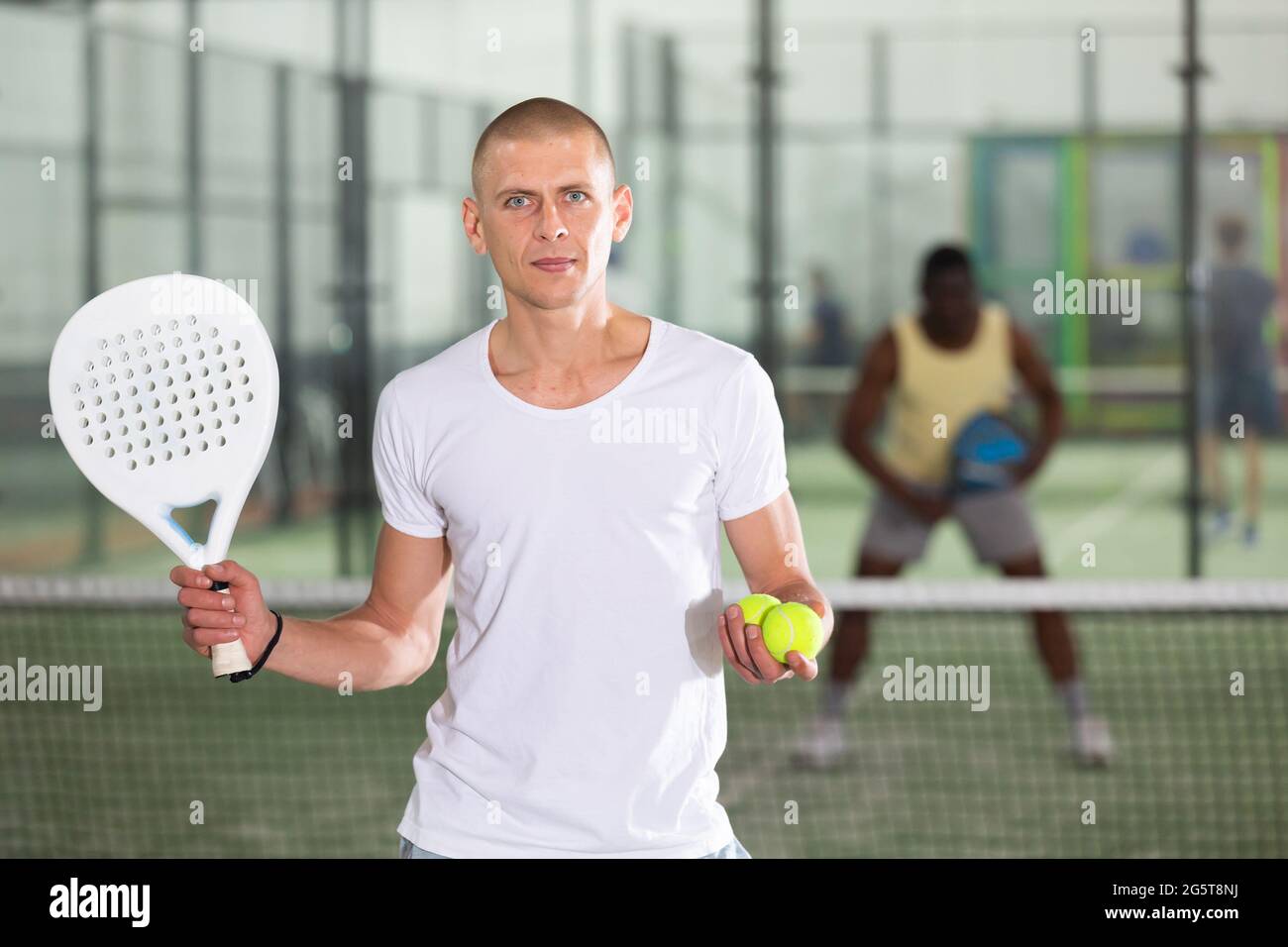 Portrait of sporty male with padel racket at court Stock Photo - Alamy