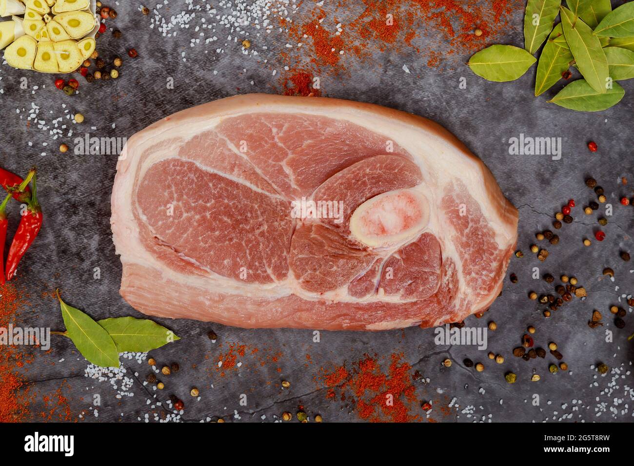 Close up of sliced raw pork shoulder with spices on dark surface. Top ...