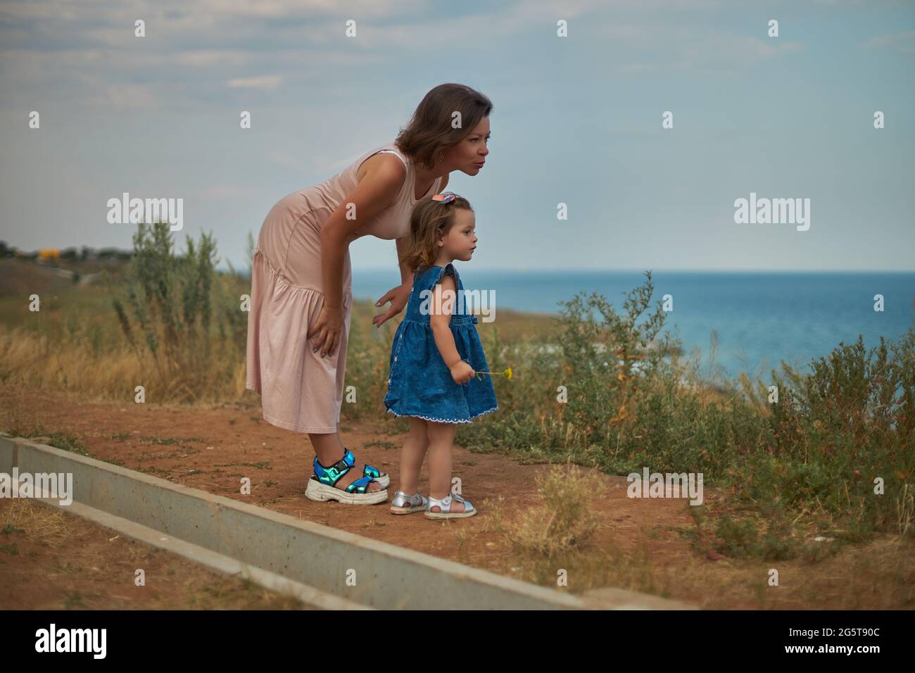 Mother leaned over to her daughter and talks about something Stock ...