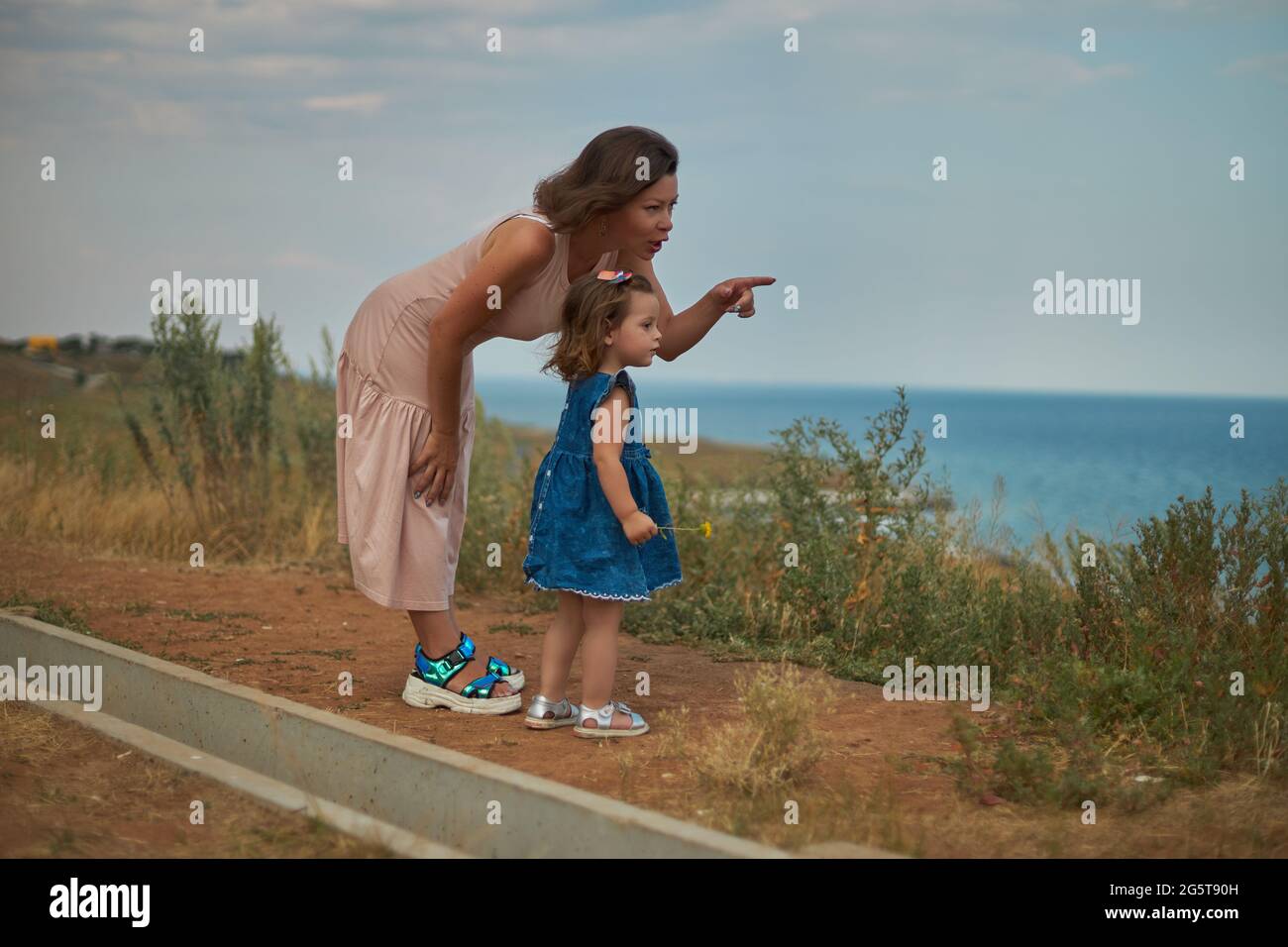 Mother points her hand to her little daughter to the horizon Stock ...