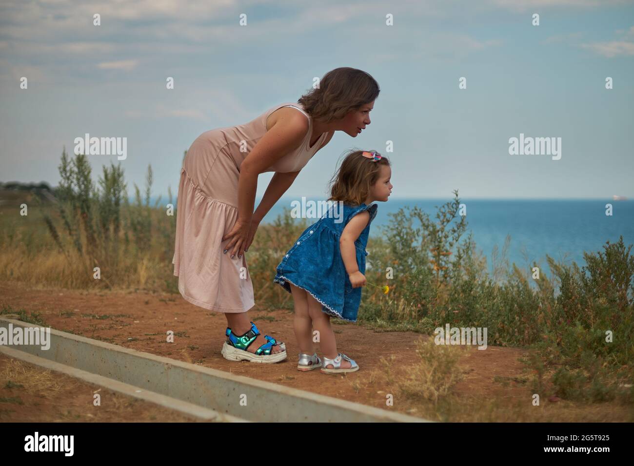 Mother leaned over to her daughter and talks about something Stock ...