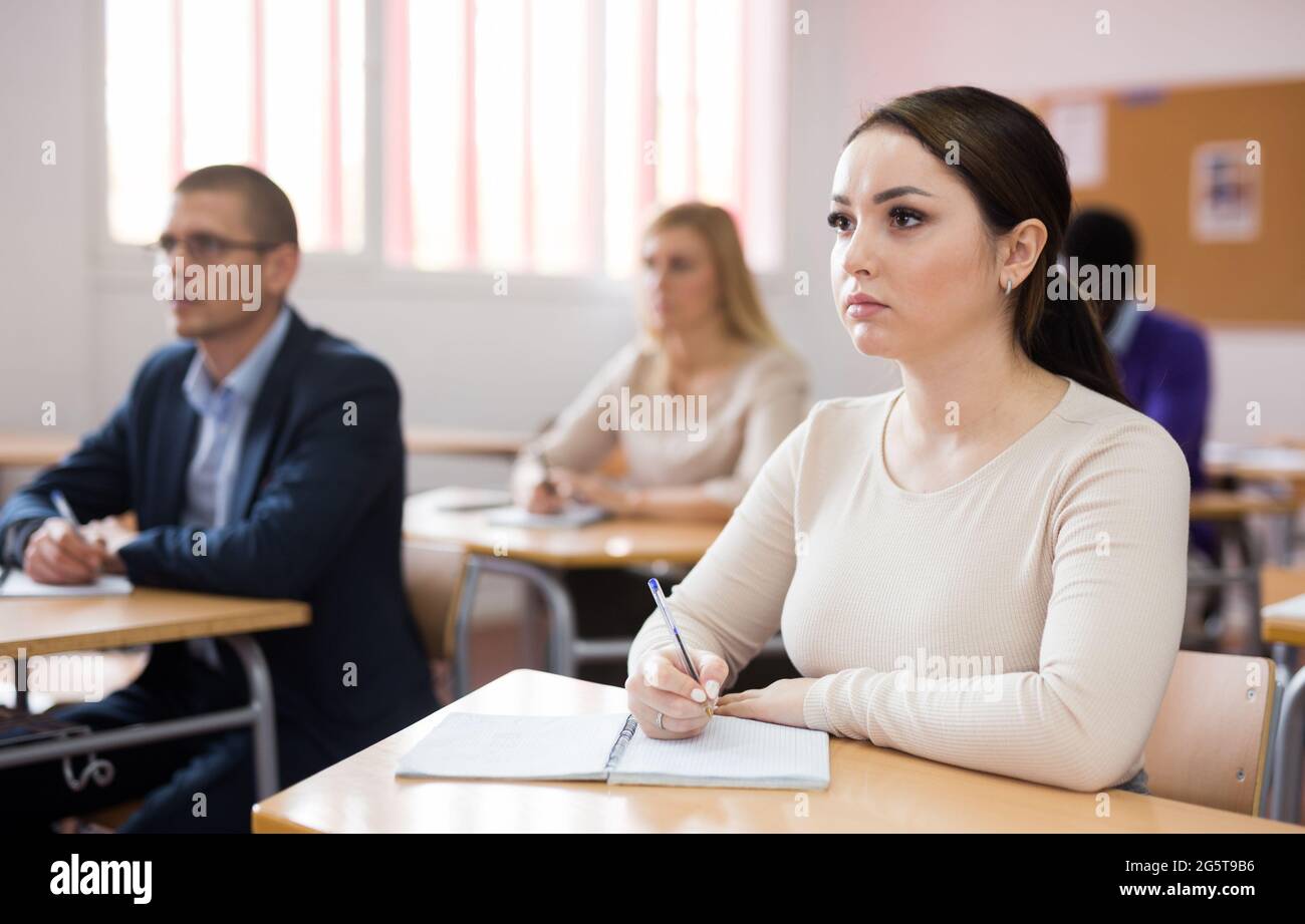 Focused young woman on lesson in school auditorium Stock Photo - Alamy