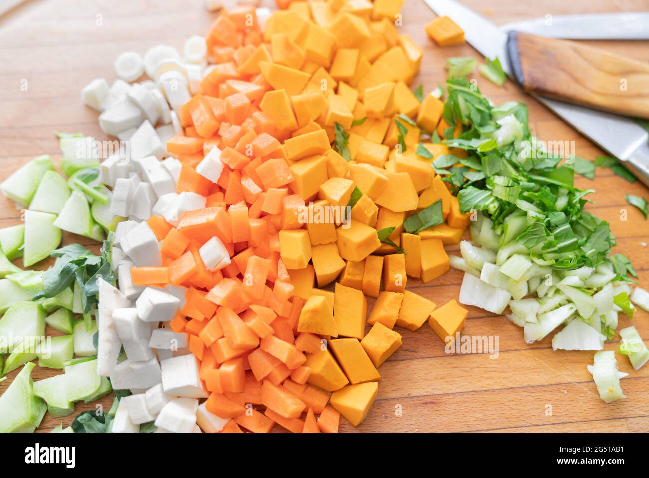 Chopped and prepared vegetables on kitchen board ready to be cooked and ...