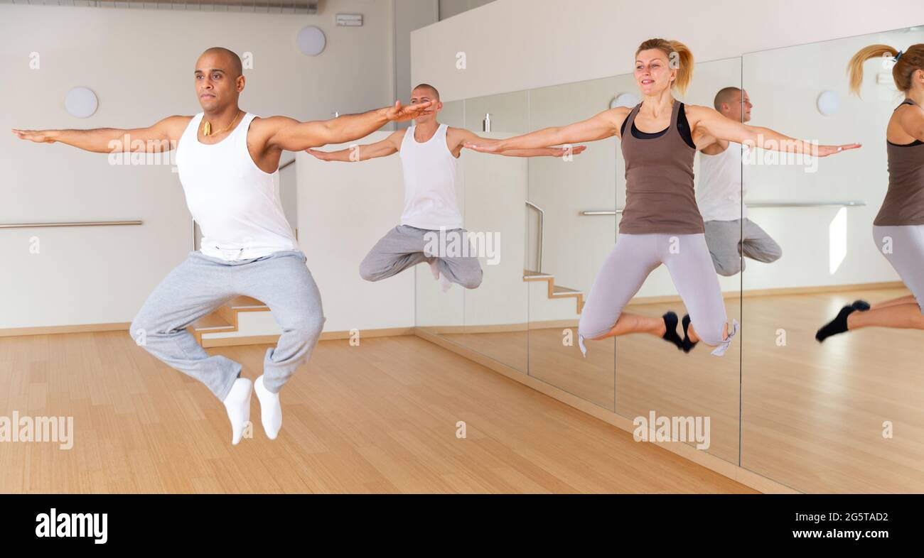 Group of active dancers in jump in dance hall Stock Photo - Alamy