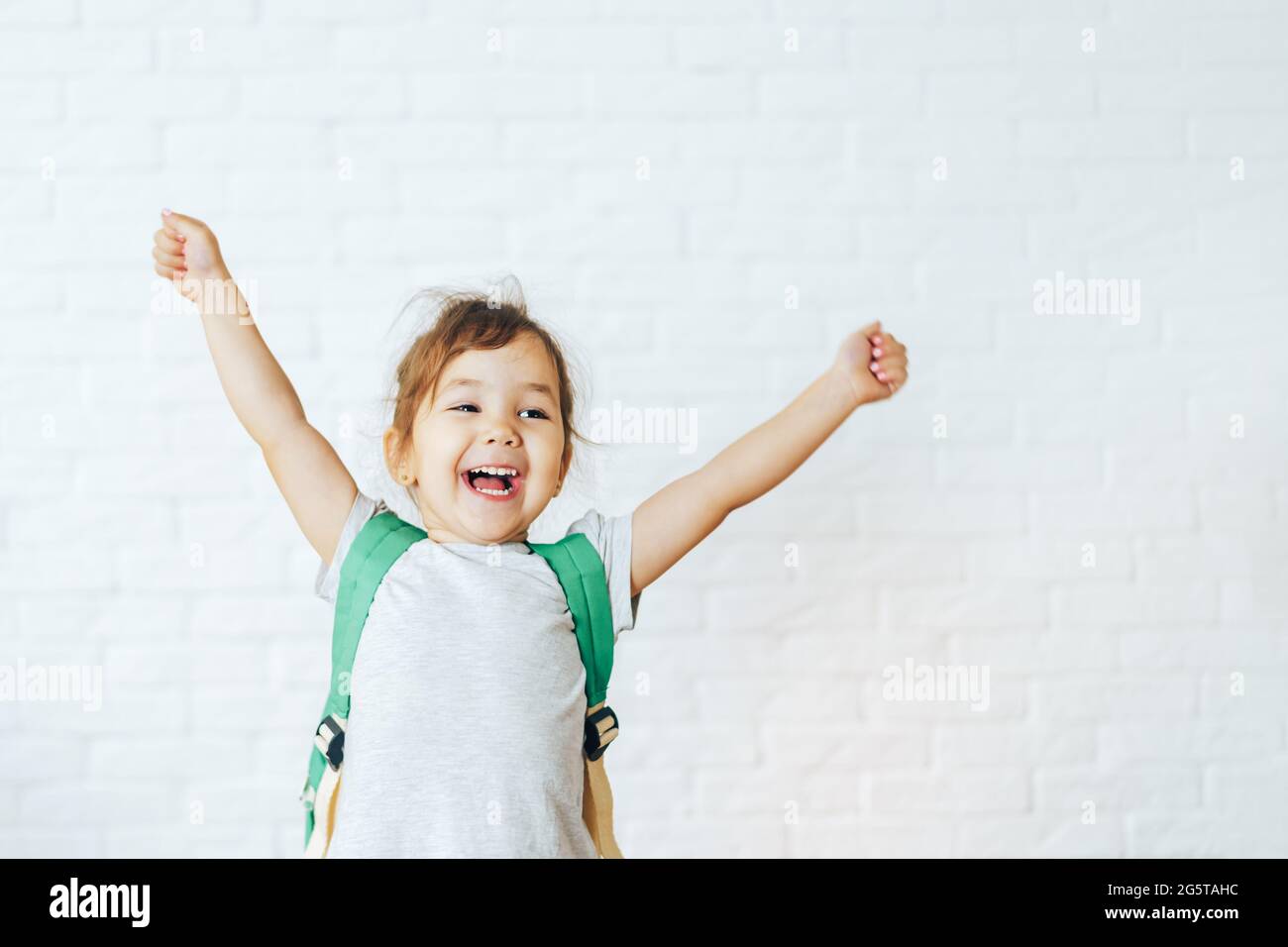 Happy child with raised hands up in front of white background Stock ...