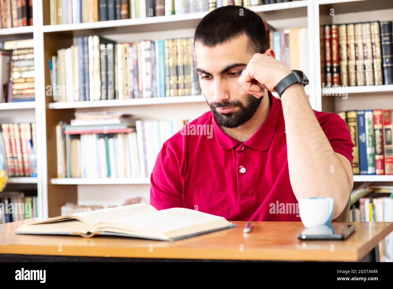 Man reading a book and drinking in the library Stock Photo - Alamy