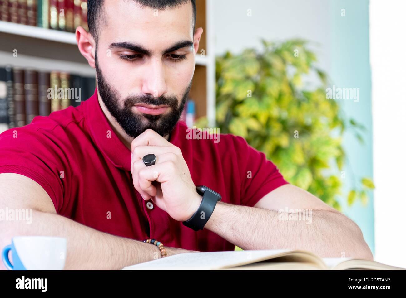 Man reading a book and drinking in the library Stock Photo - Alamy