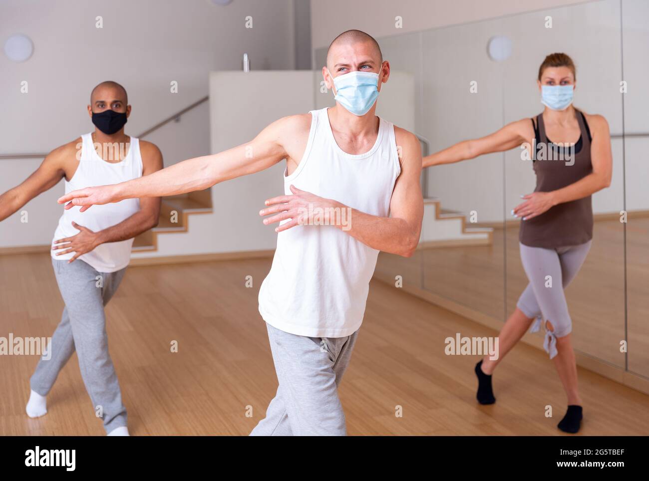 People in protective masks learning swing steps at class Stock Photo ...