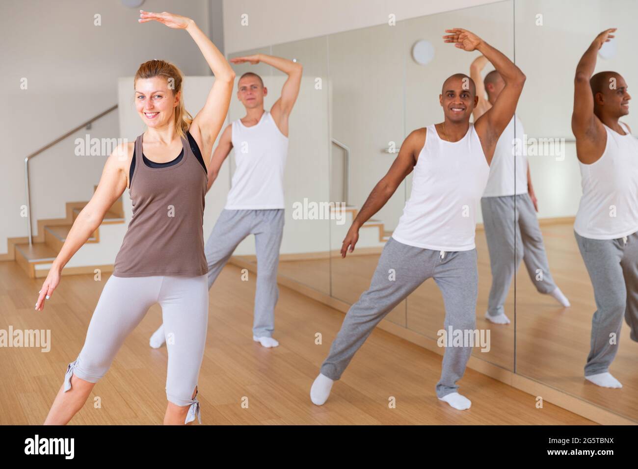 Happy adults training swing steps at class Stock Photo - Alamy
