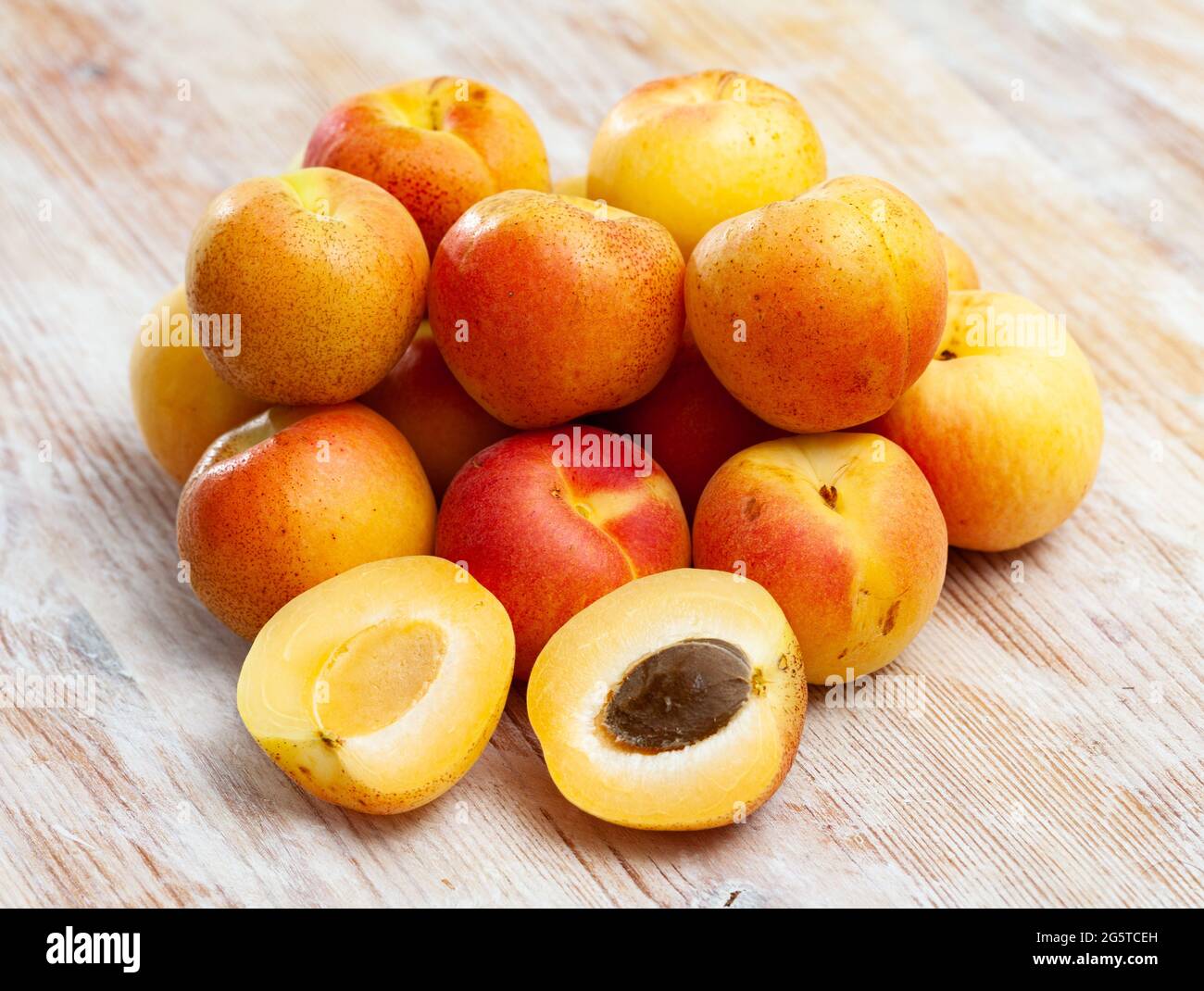 Image of ripe juicy apricots on wooden table in kitchen Stock Photo - Alamy
