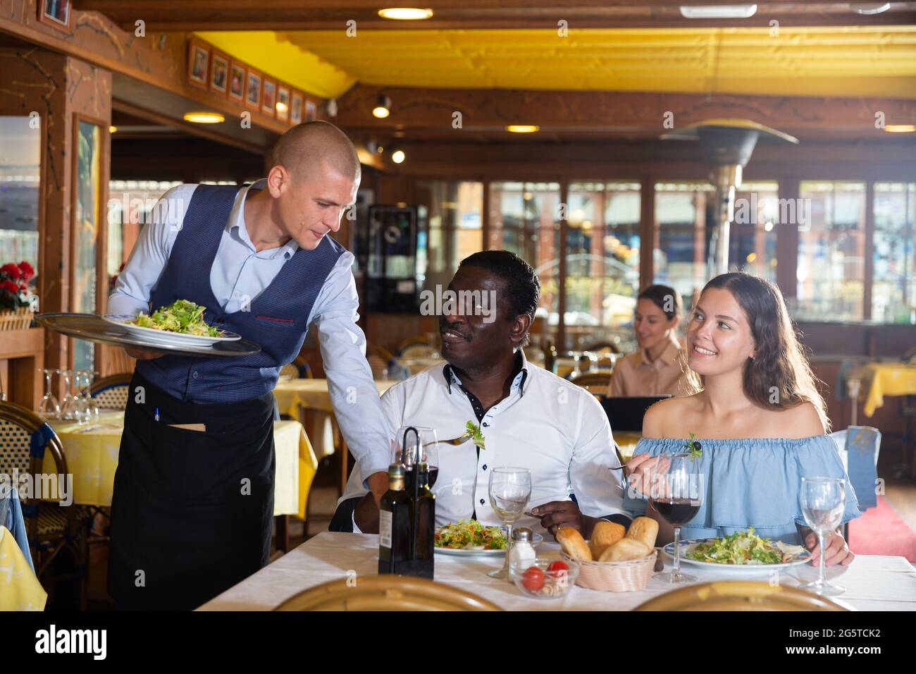 Male waiter writing down order from visitors in restaurant Stock Photo ...