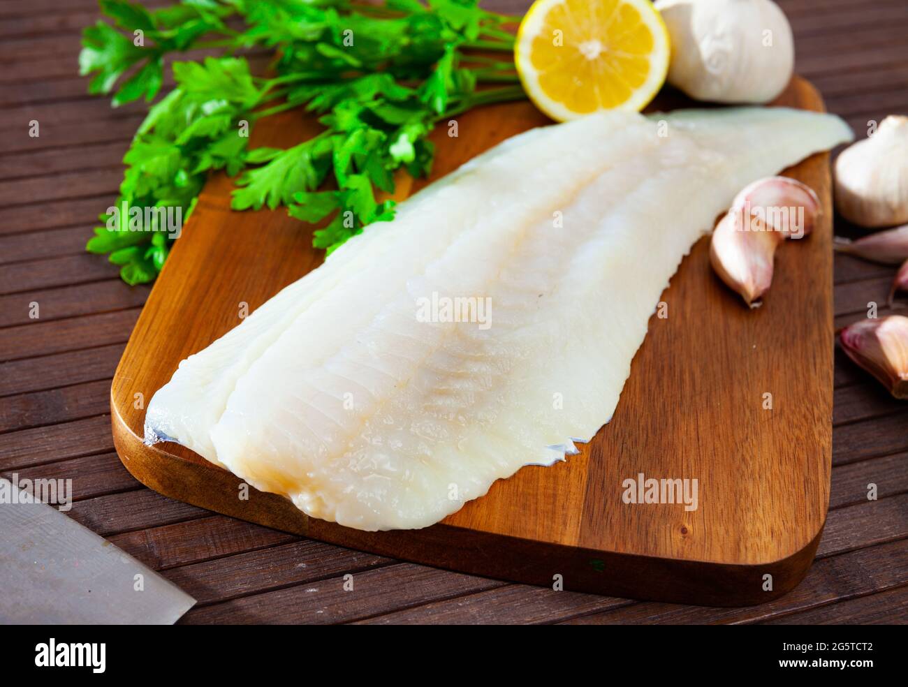 Fillet of raw cod fillet before cooking on wooden background Stock ...
