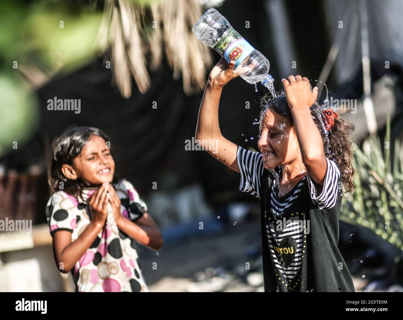 Gaza, Palestine. 29th June, 2021. A Palestinian girl pours water on ...