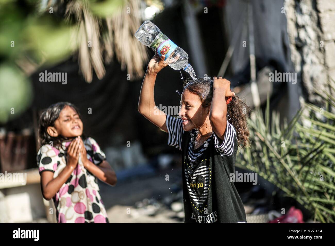 Gaza, Palestine. 29th June, 2021. A Palestinian girl pours water on ...