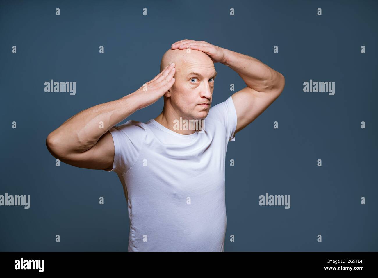 Funny bald man posing on a blue background with excited facial ...
