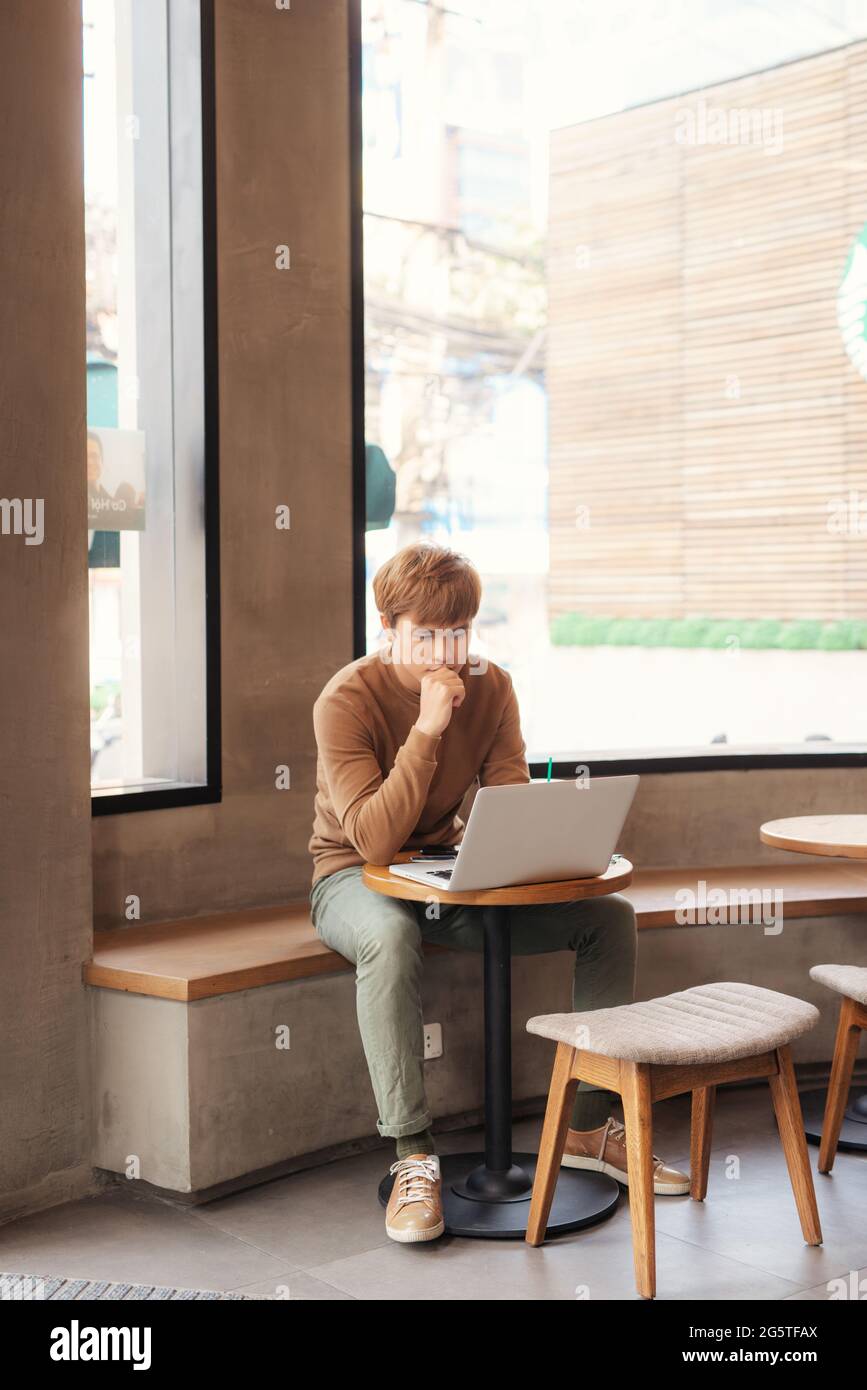 Young man studying and reading at the coffee shop Stock Photo - Alamy