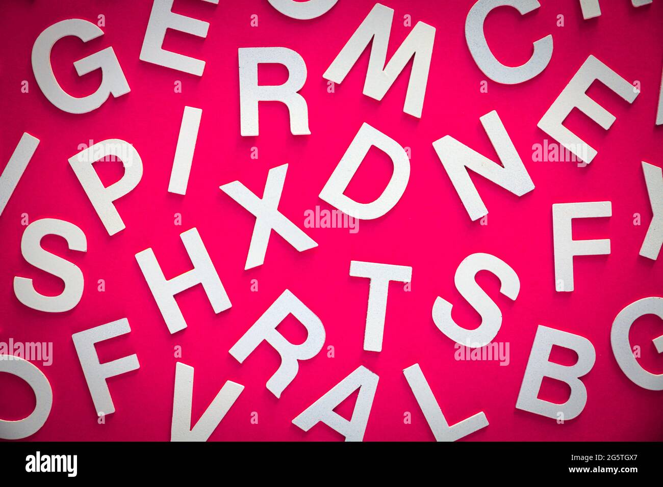 Mixed solid letters pile top view photo. Education concept on pink ...