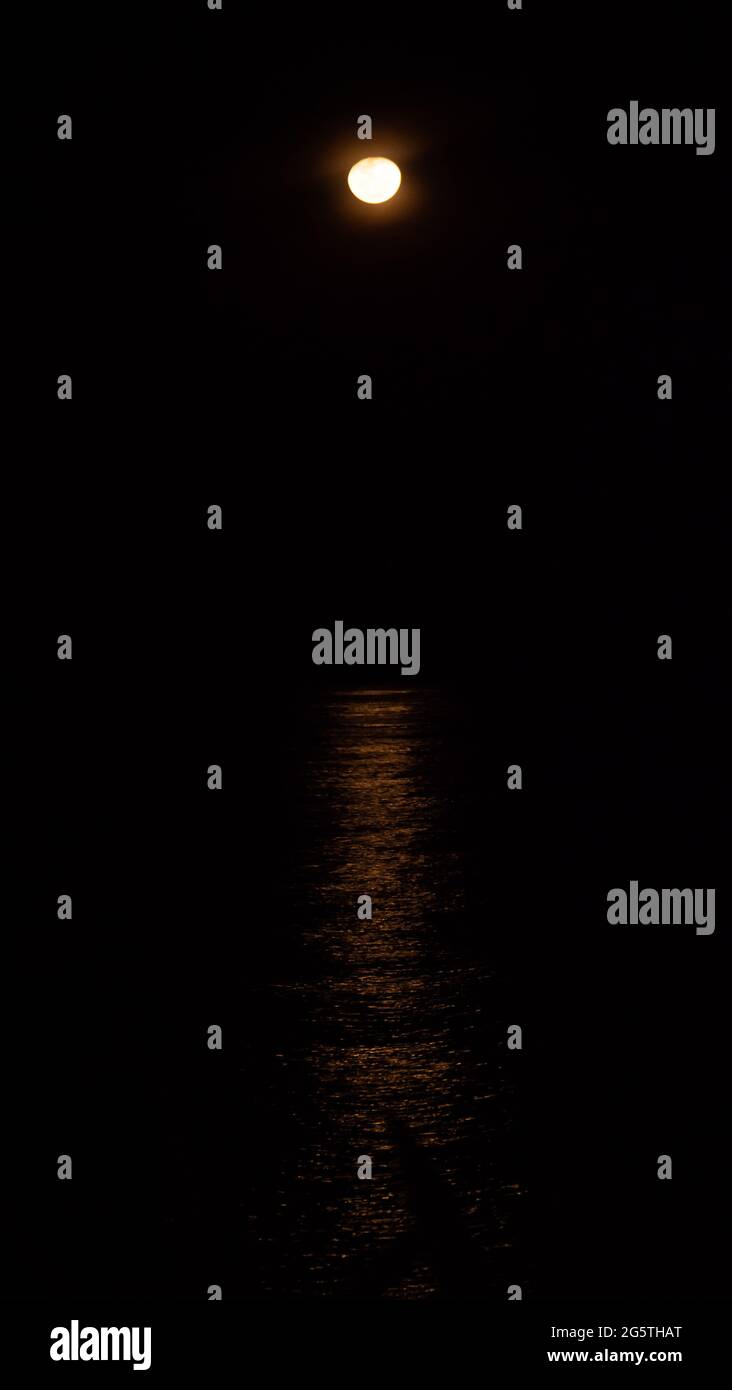 moonlight reflections on sea. Full moon setting on horizon in ocean ...