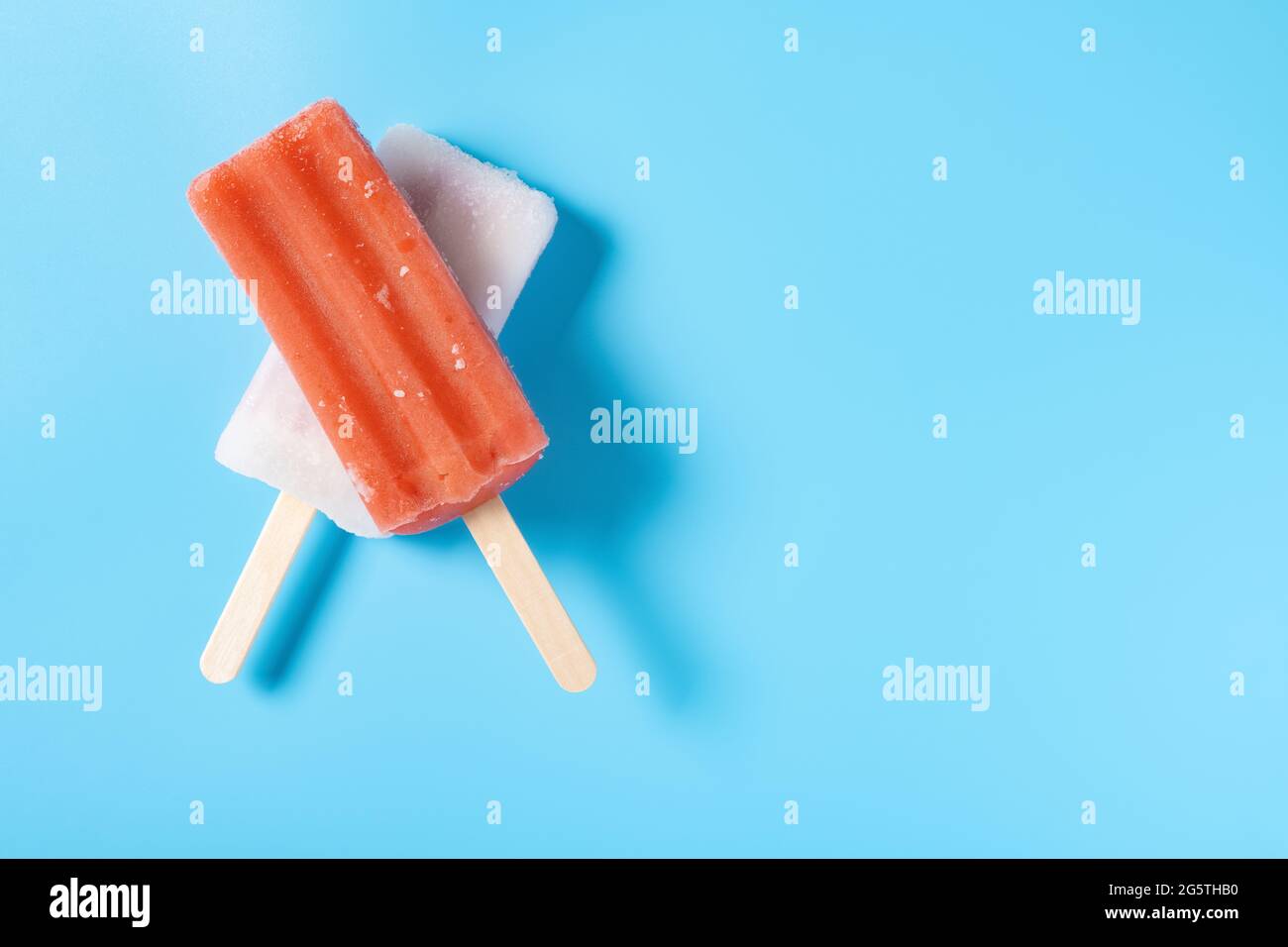 top view fresh red popsicle and white popsicle on a blue background ...