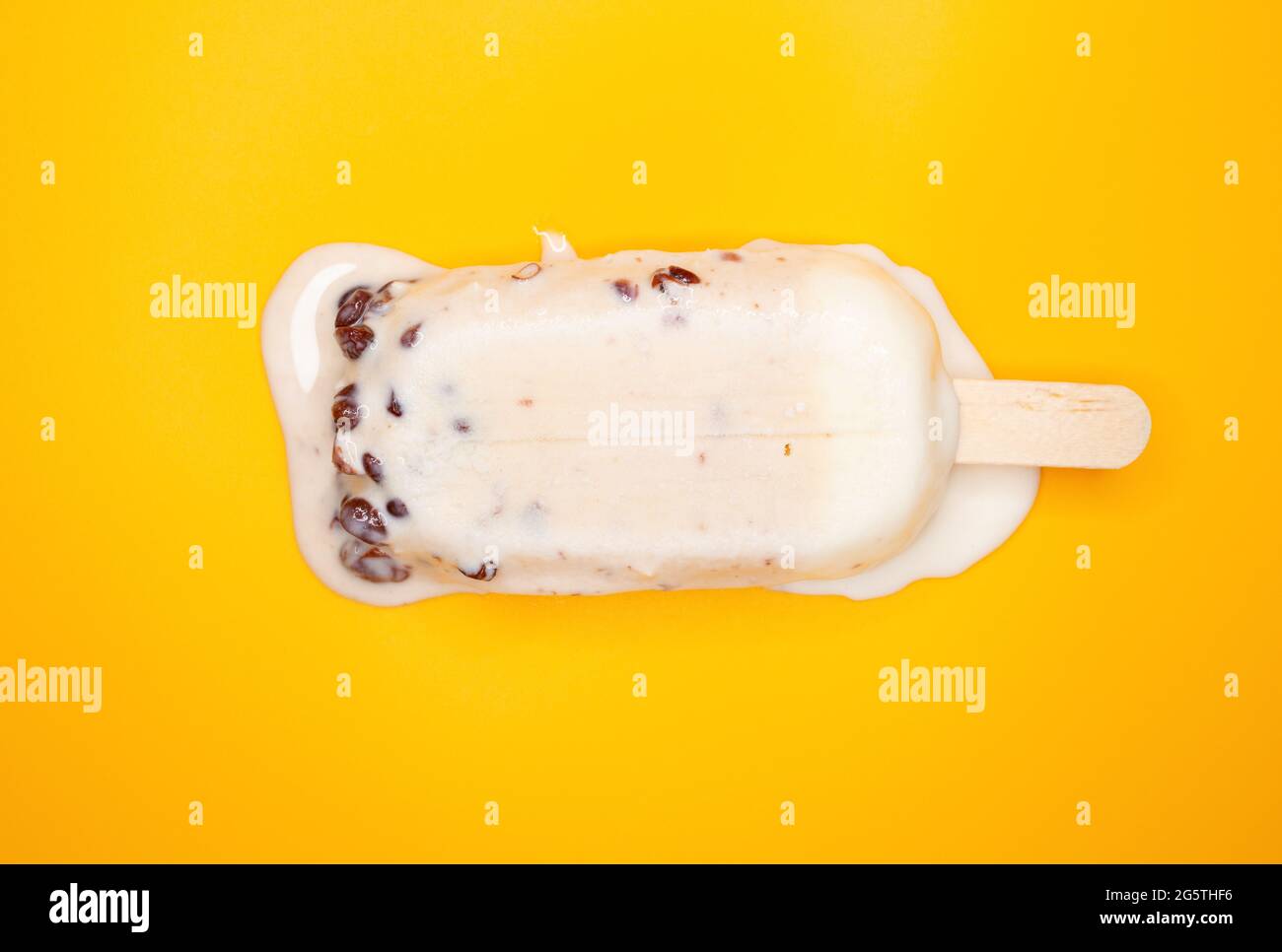 top view milkshake flavor popsicle with red beans starts melting on a ...