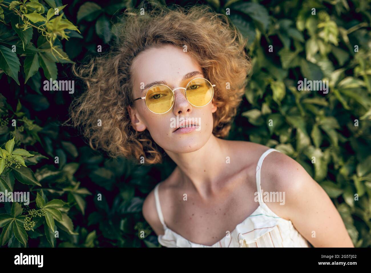 Cute woman in sunglasses on the greenery background Stock Photo - Alamy