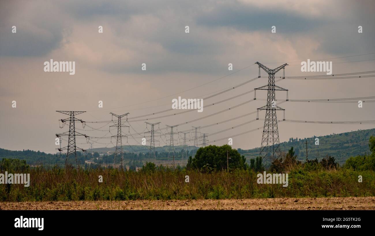 High-voltage electric wire towers standing in the fields in the ...