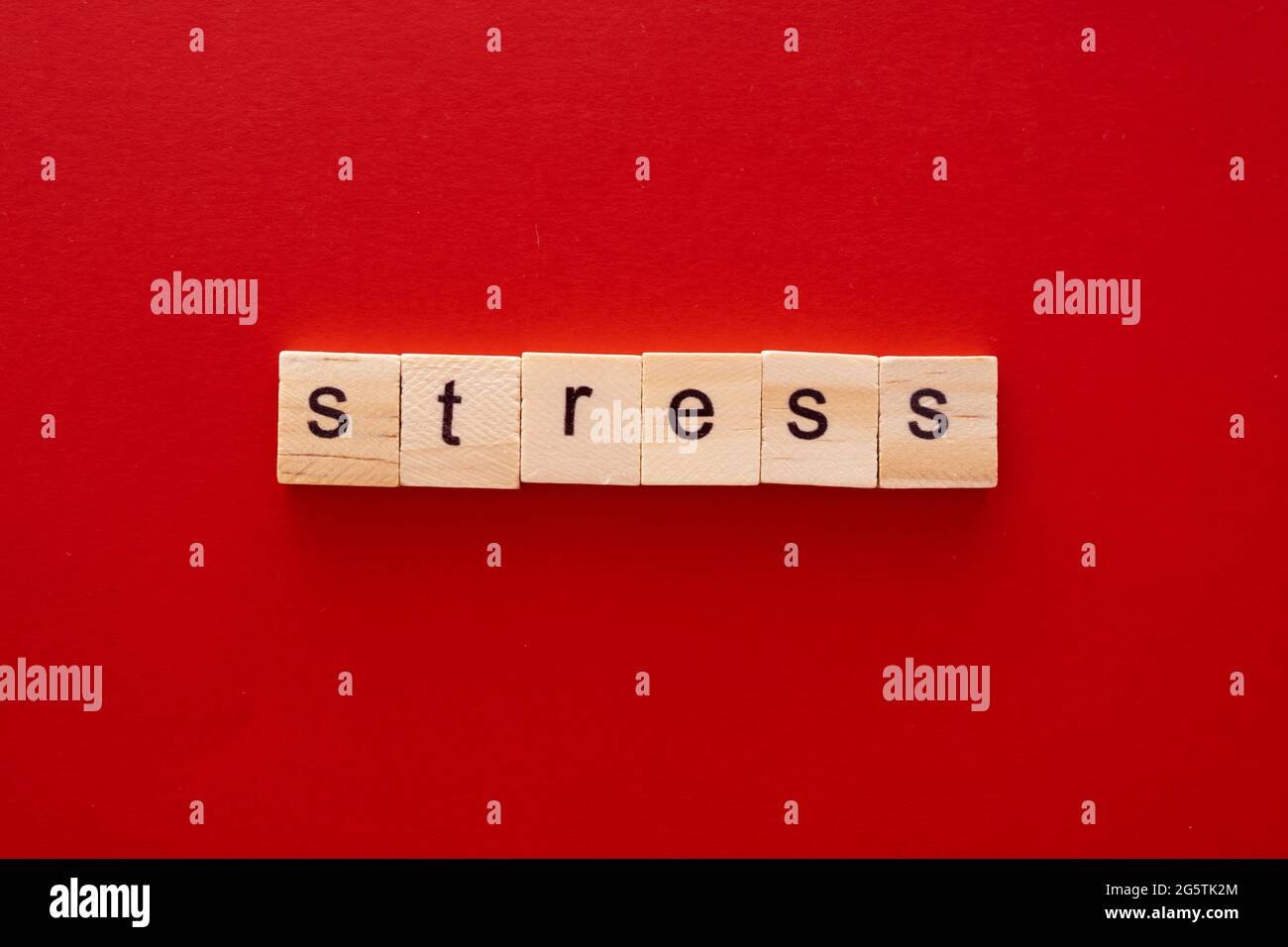 word STRESS made of wooden letters on red background with copy space ...