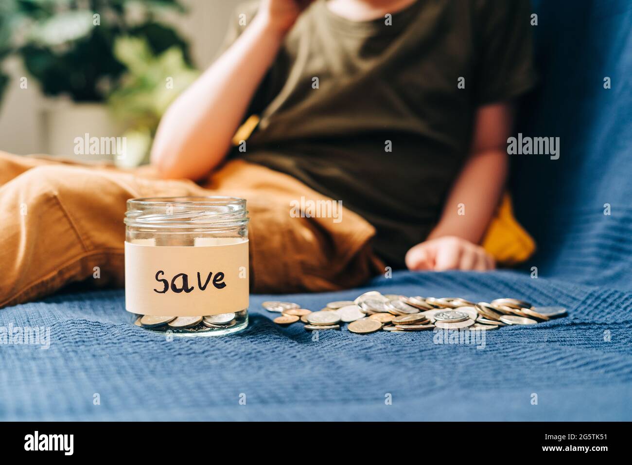 Close up of Little child kid boy hands grabbing and putting stack coins ...