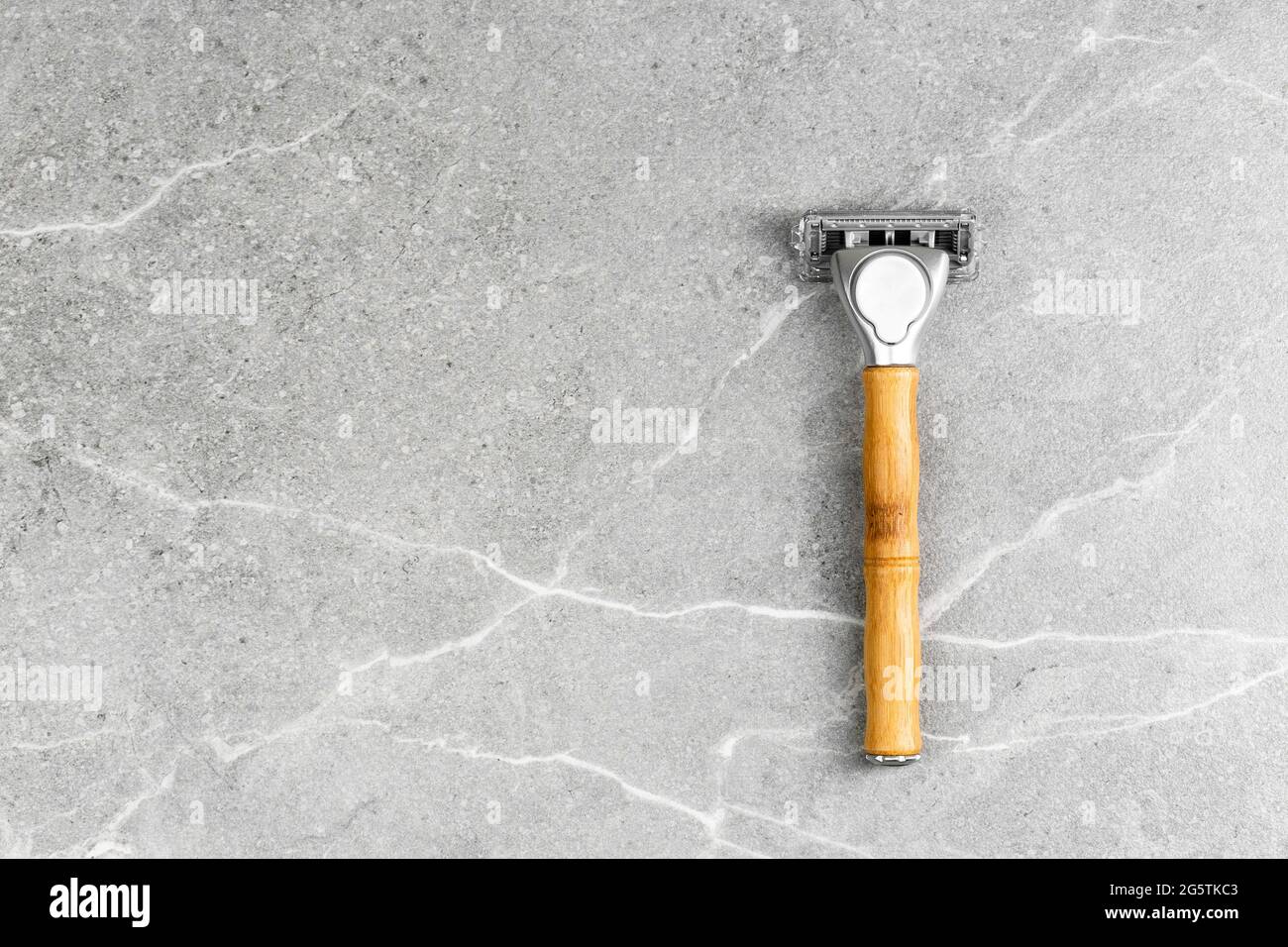 Shaving Razor with wooden handle on a grey marble background. Plastic ...