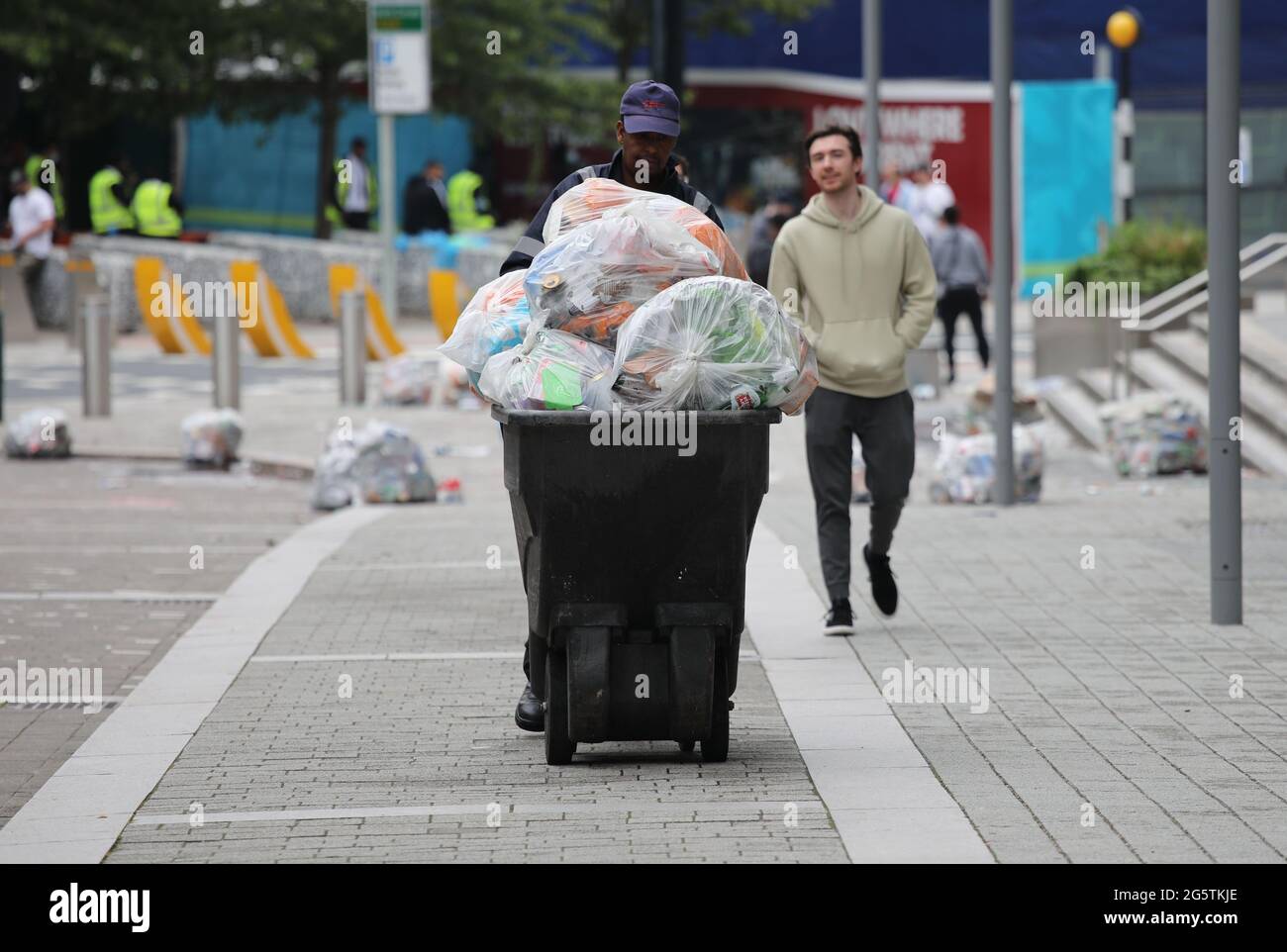 London, UK. 29th June, 2021. A worker collects rubbish left by football ...