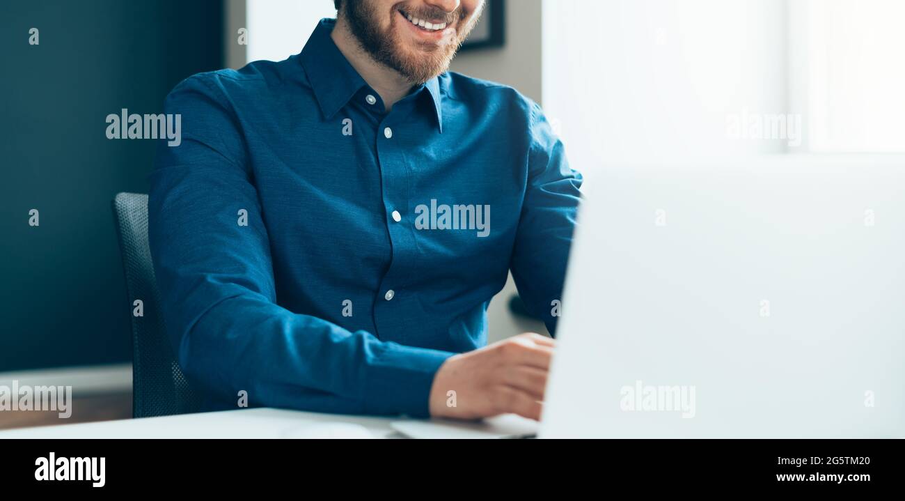 Faceless happy young male office employee working on laptop computer ...