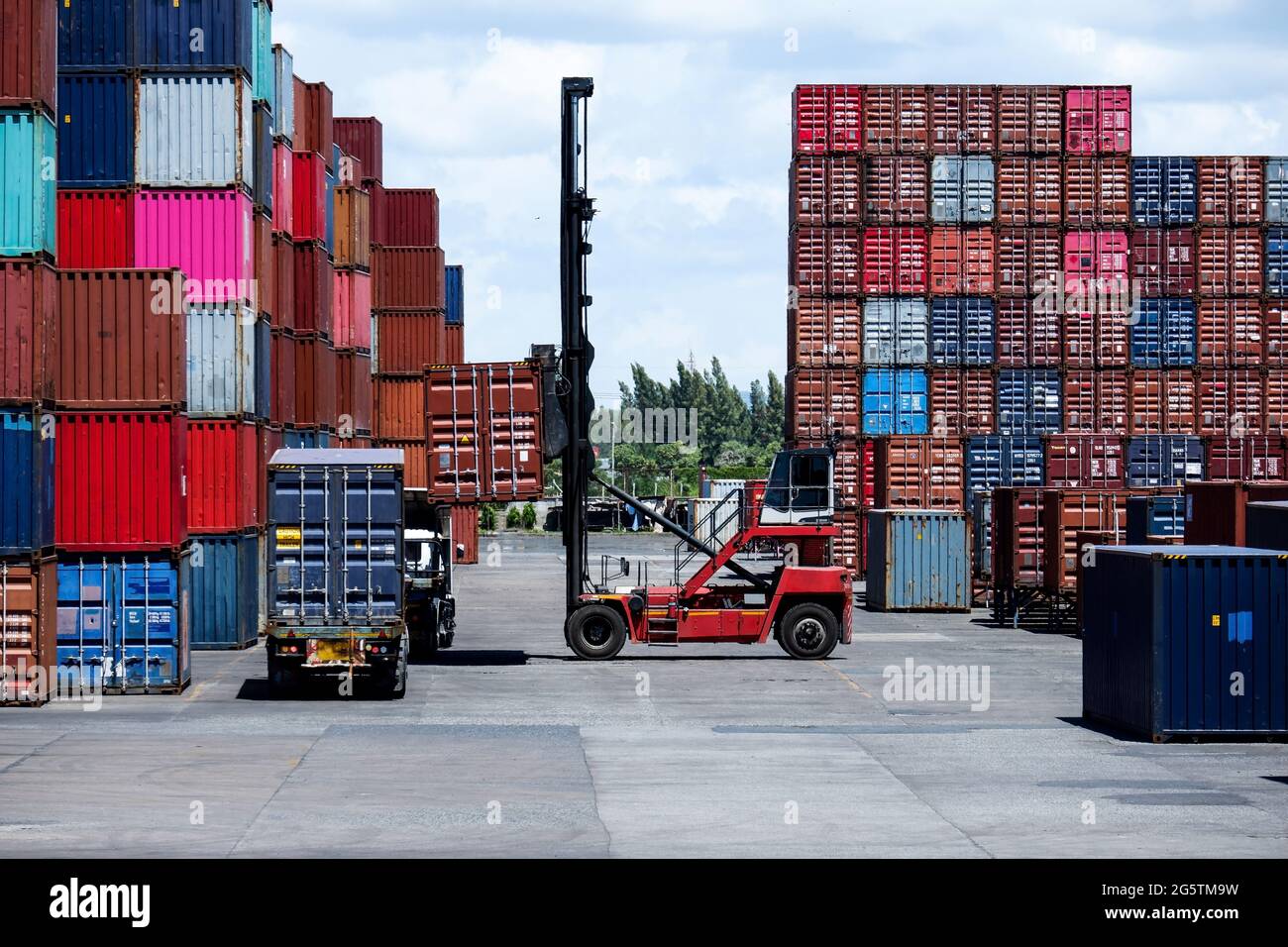 Forklift truck lifting cargo container in shipping yard or dock yard ...