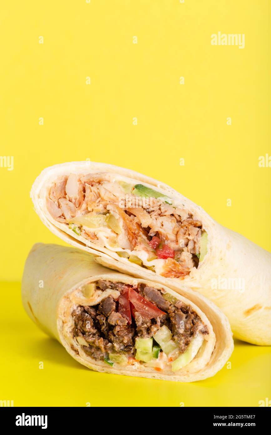 Doner roll shawarma with chicken and vegetables on yellow Stock Photo ...