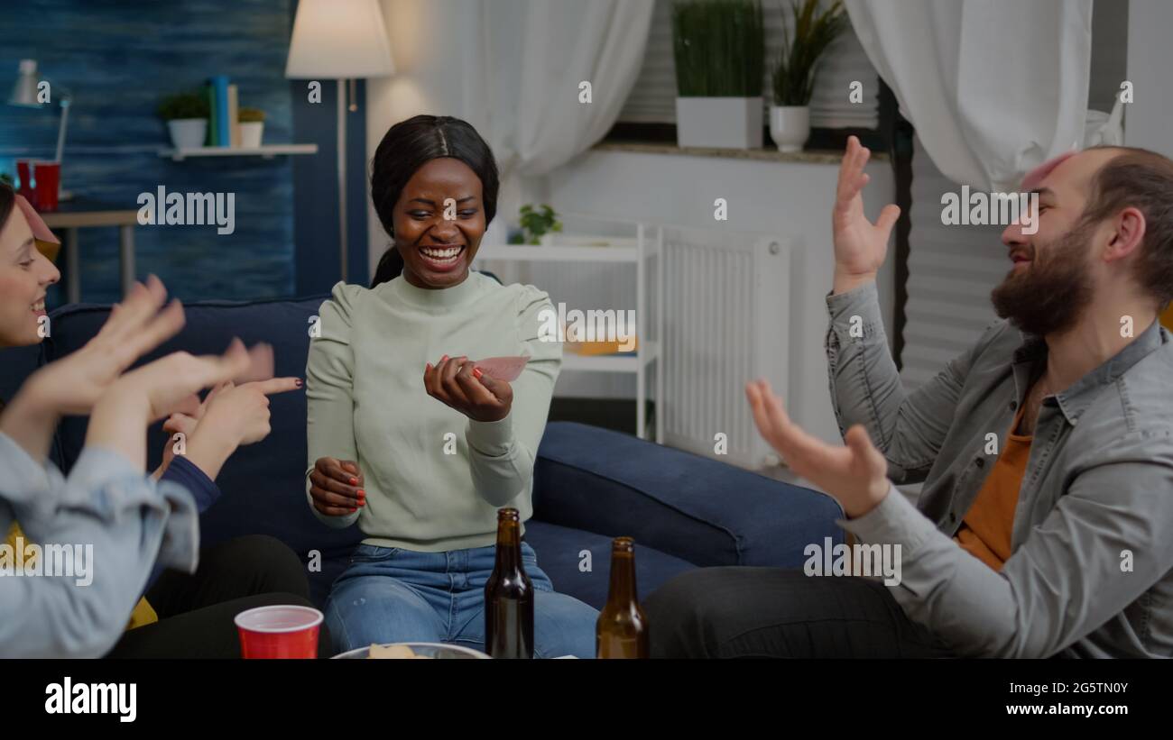 Multiracial friends playing Guess who game with sticky papers attaching ...