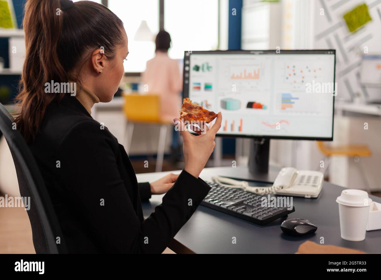 Businesswoman enjoying food meal order in company office during takeout ...