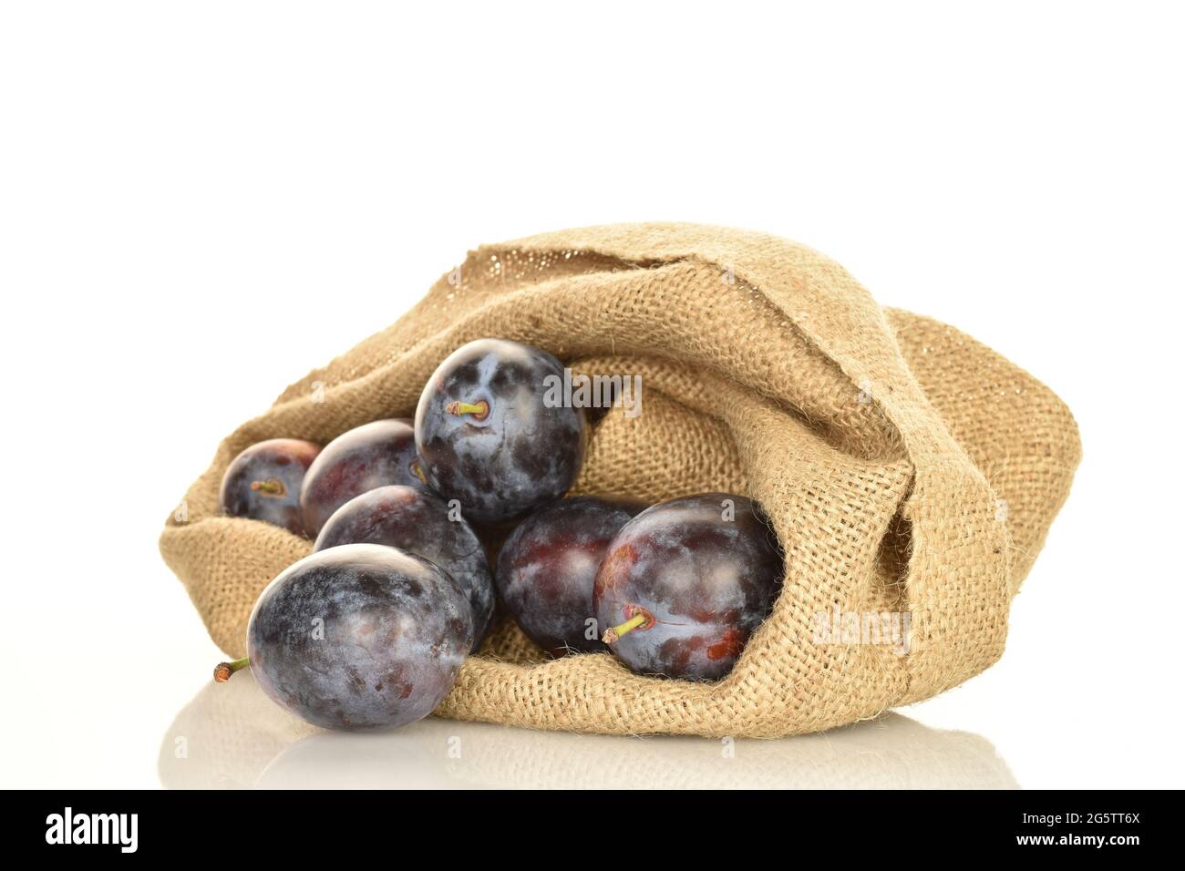Several organic plums in a jute bag, close-up, isolated on a white ...