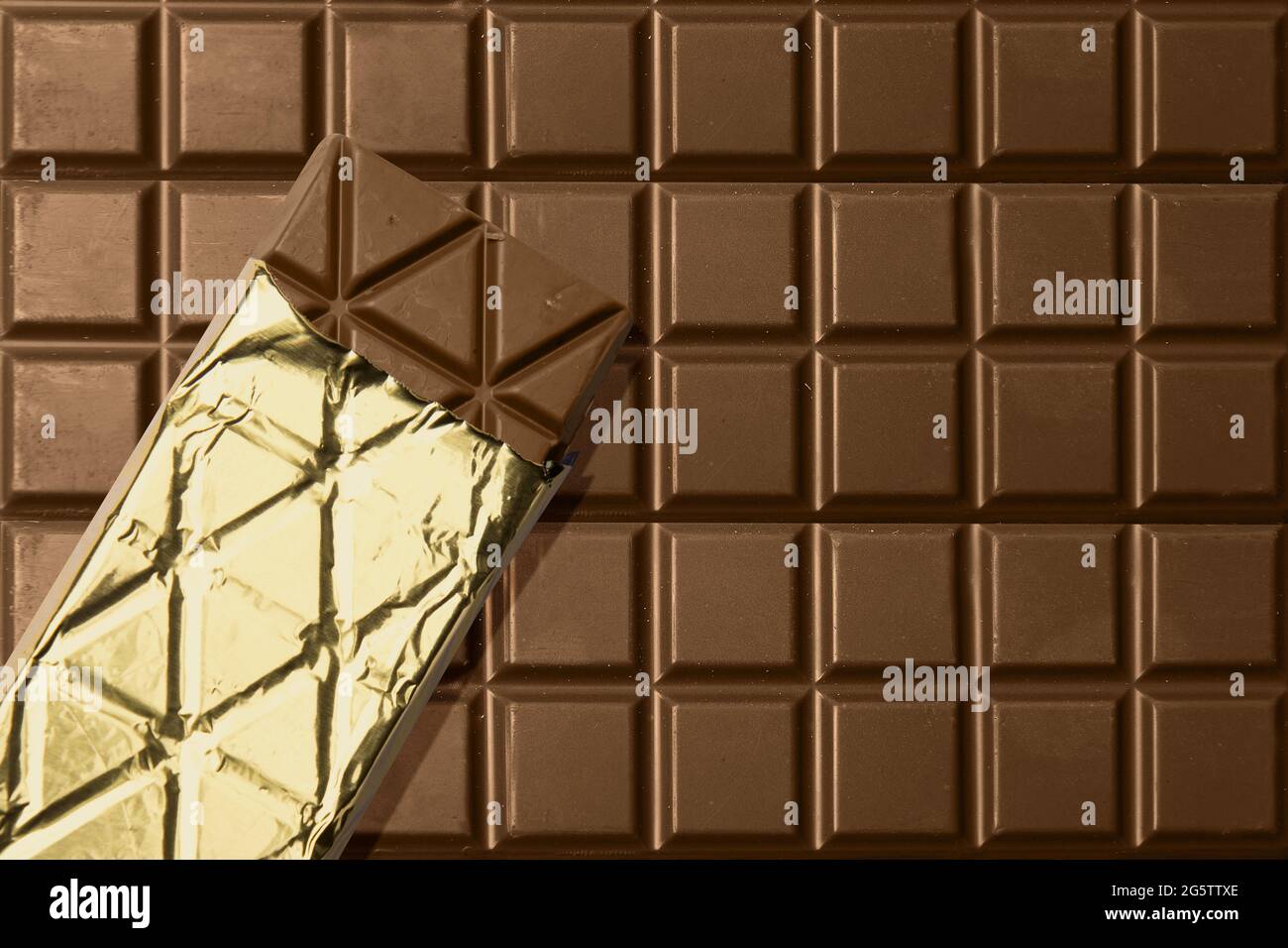Wrapped chocolate bar with chocolate bar background Stock Photo - Alamy