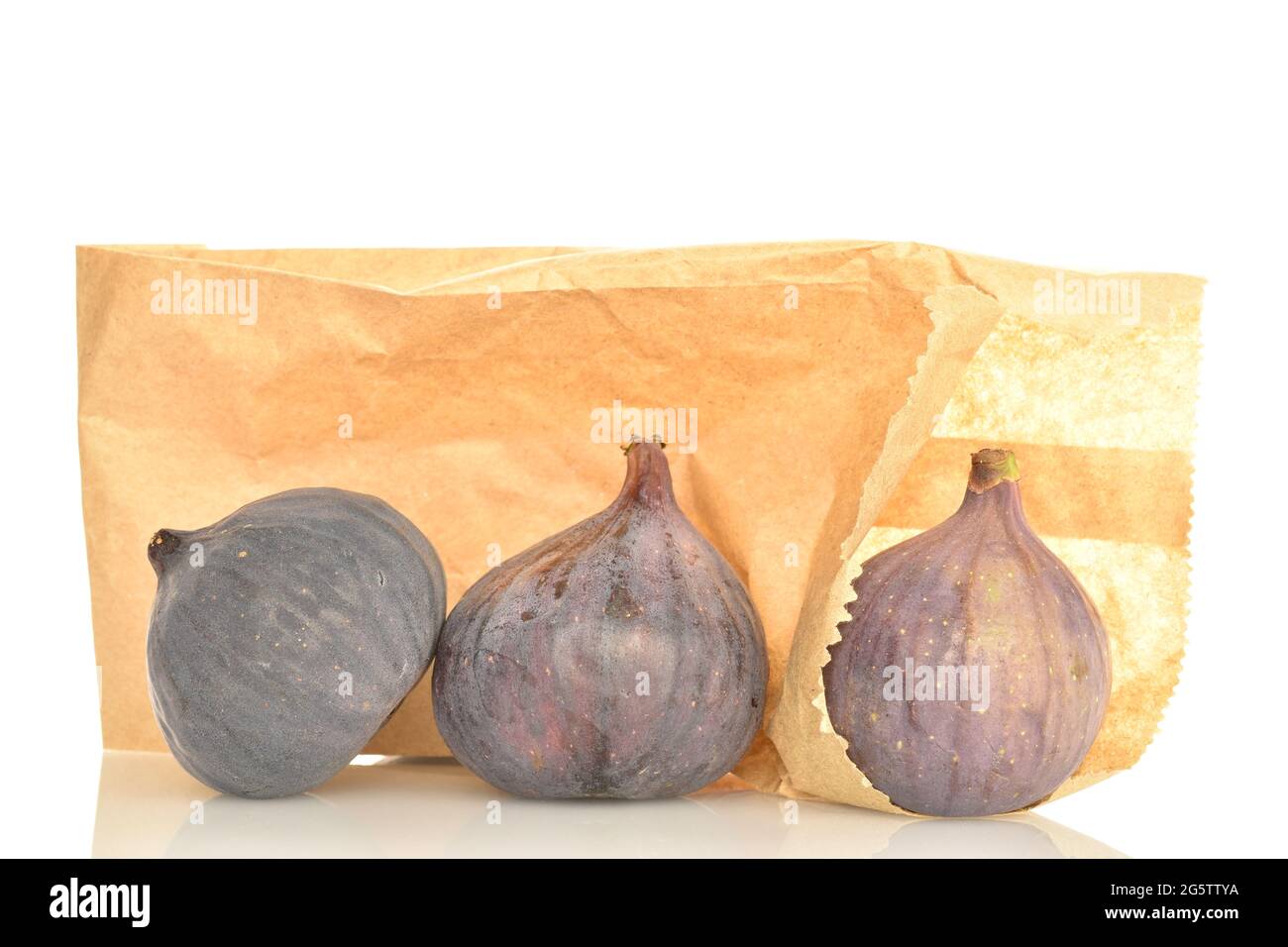 Several ripe dark purple, organic figs with a package of paper, close ...