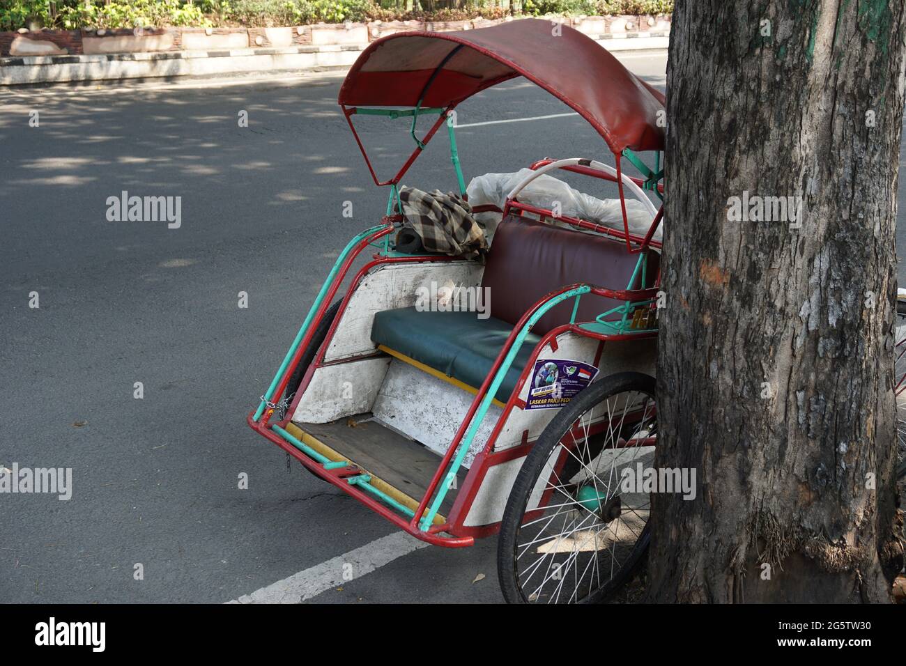 Becak on the side walk. Becak is one of traditional indonesian ...
