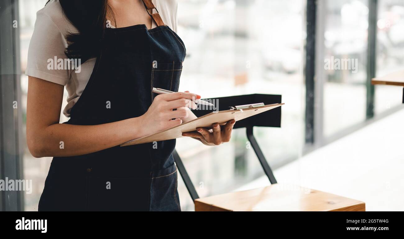 Close up female waitress take order cafe restaurant visitors couple ...