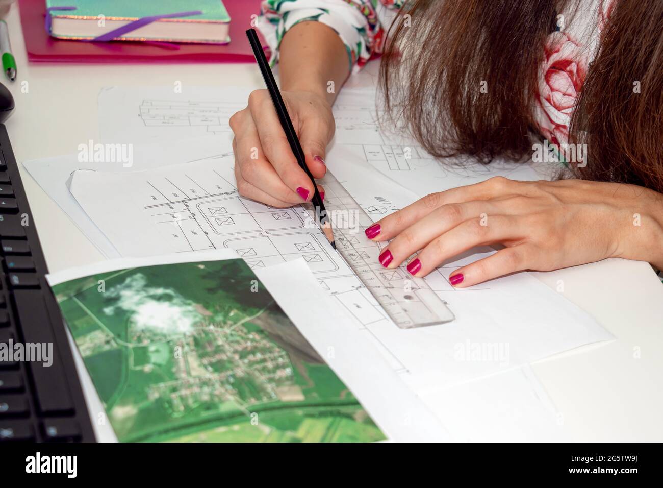 An architect is measuring and doing the technical drawing, planning the ...
