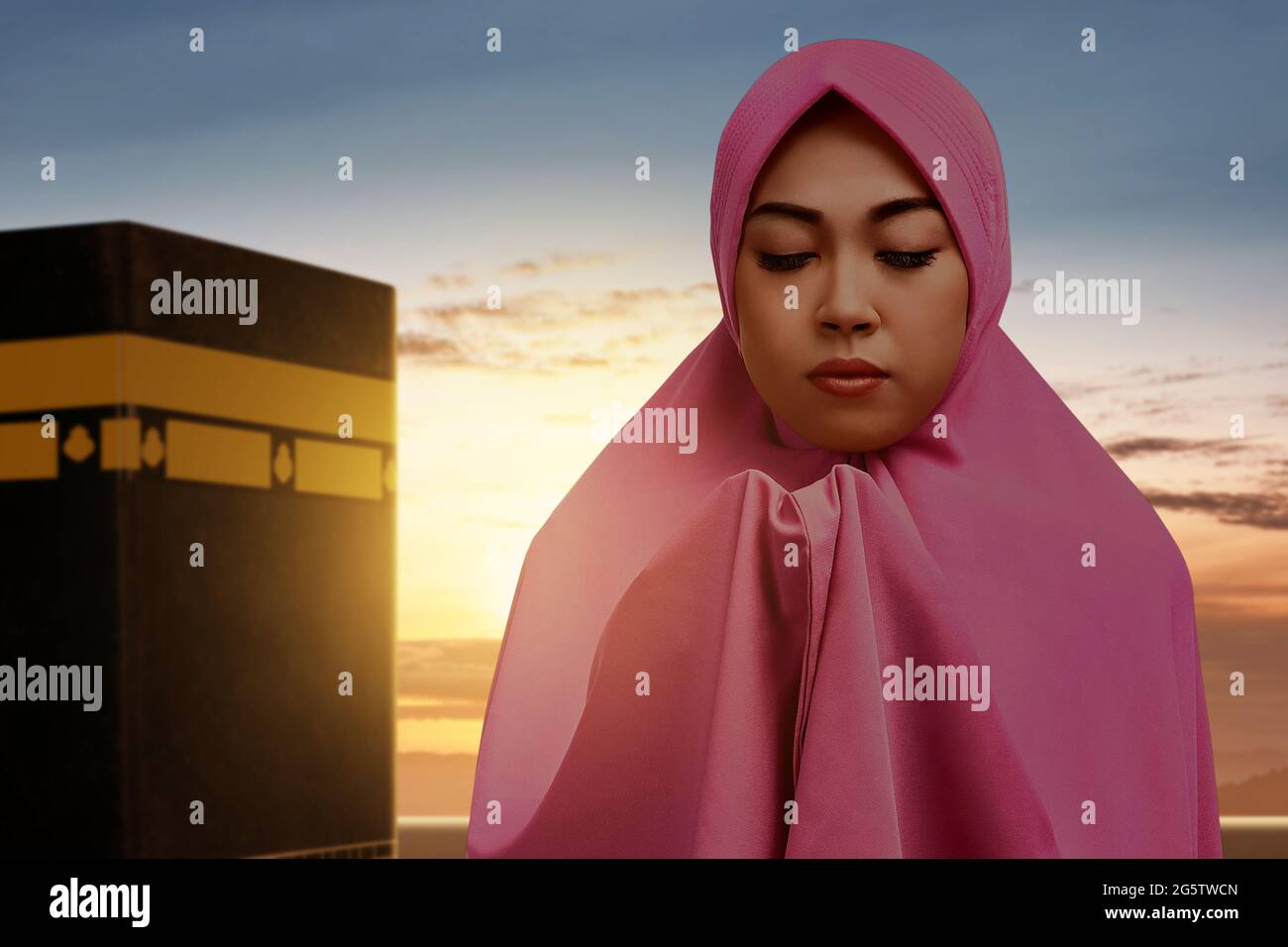 Asian Muslim woman in a veil standing and praying with Kaaba view and ...