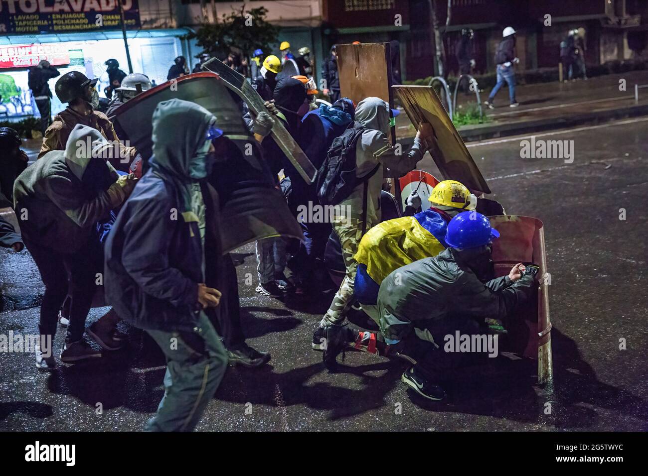 Bogota, Colombia. 27th June, 2021. Members of the front line take cover ...