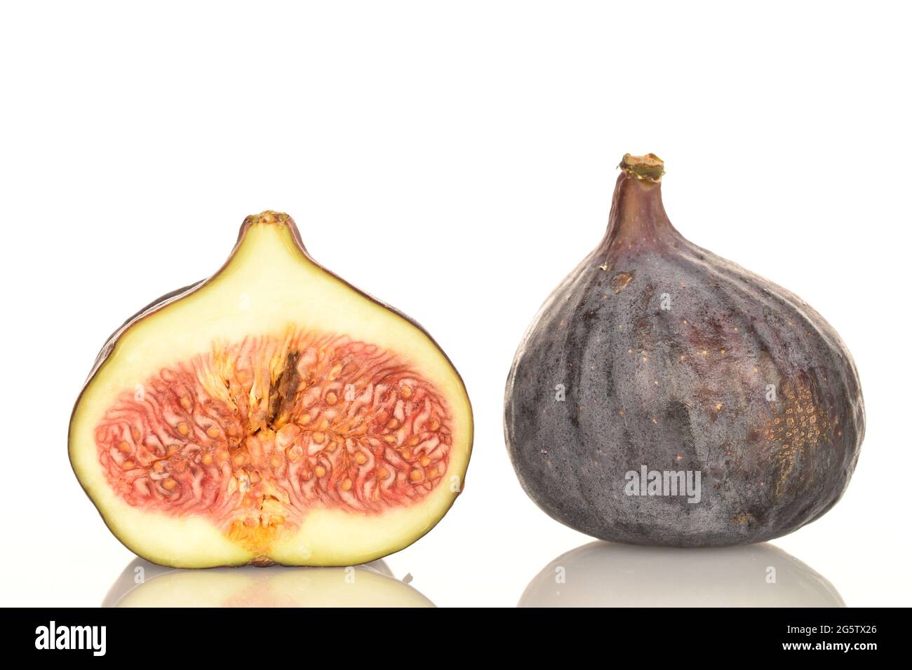 One half and a whole juicy organic figs, close-up, isolated on white ...