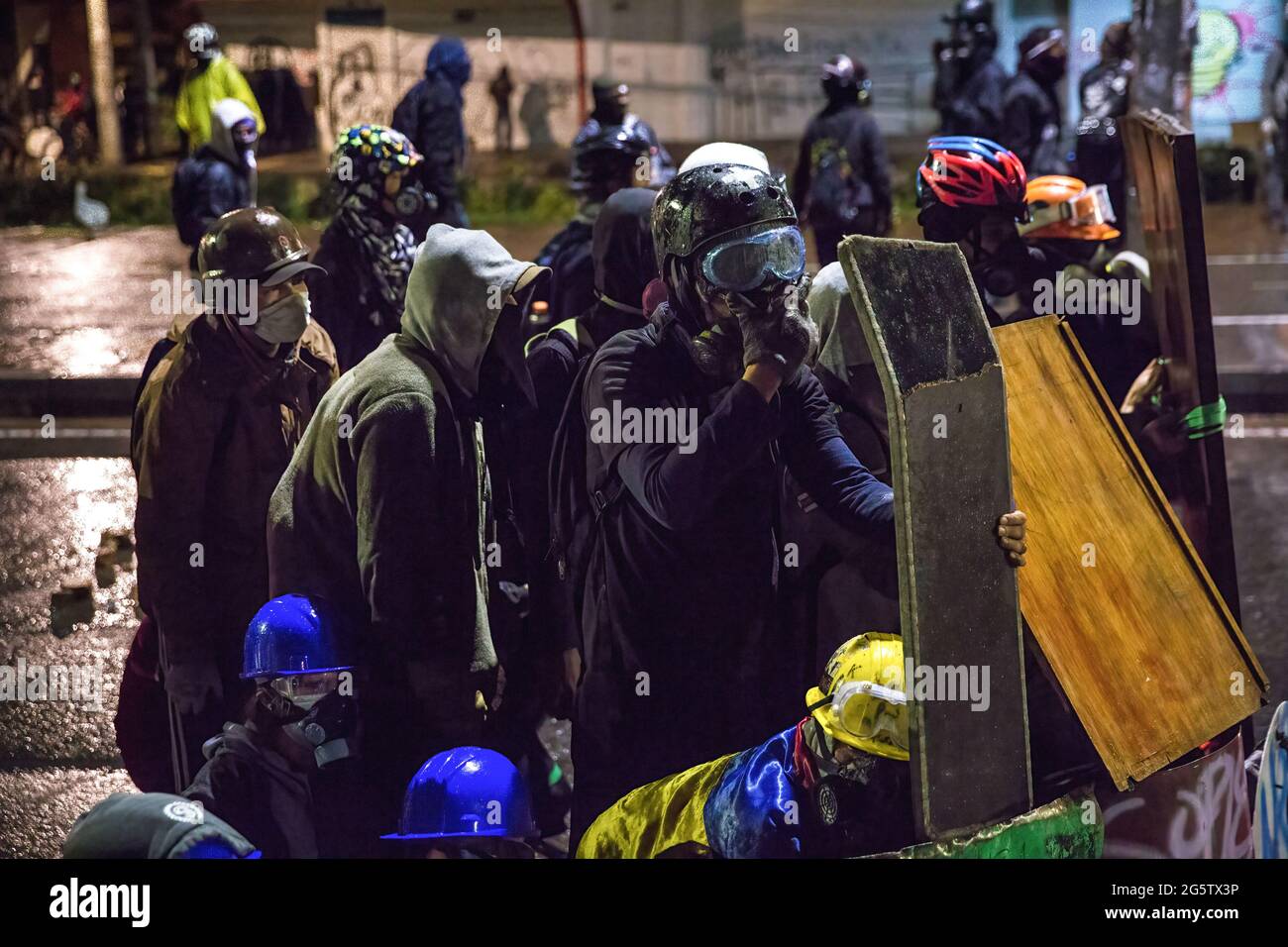 Bogota, Colombia. 27th June, 2021. Members of the front line take cover ...