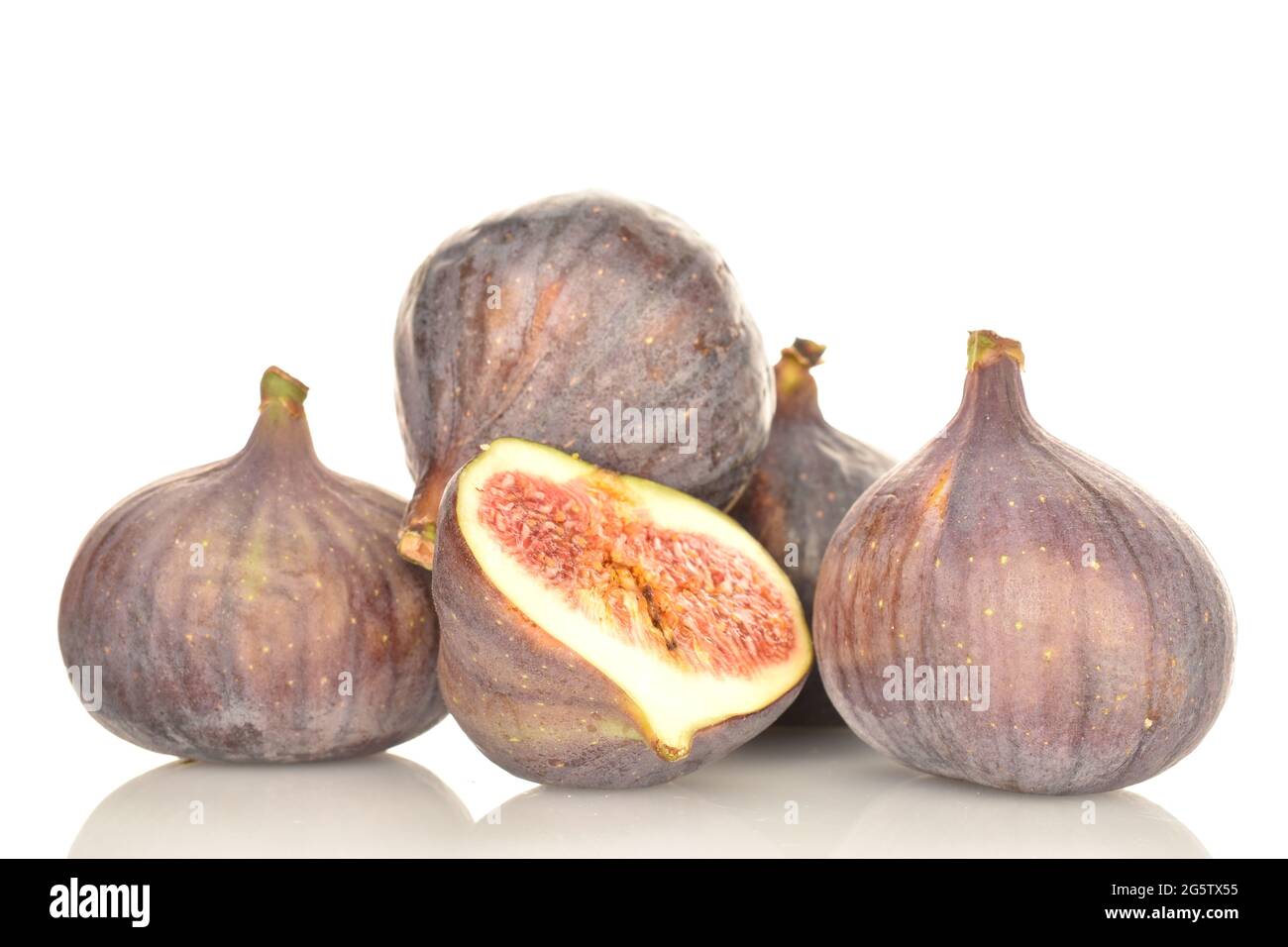 Several whole and one half ripe dark purple figs, close-up, isolated on ...