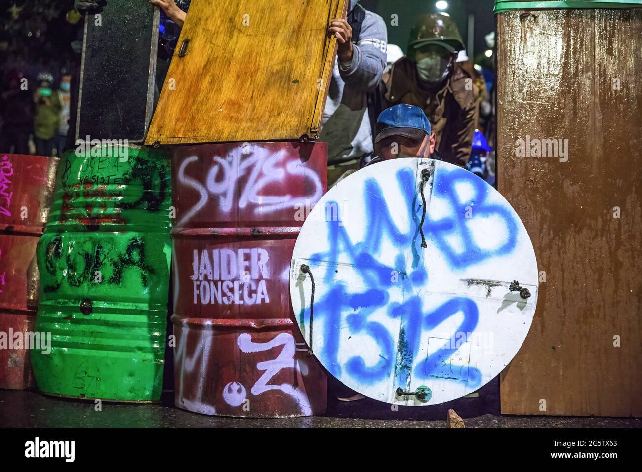 Bogota, Colombia. 27th June, 2021. Members of the front line take cover ...