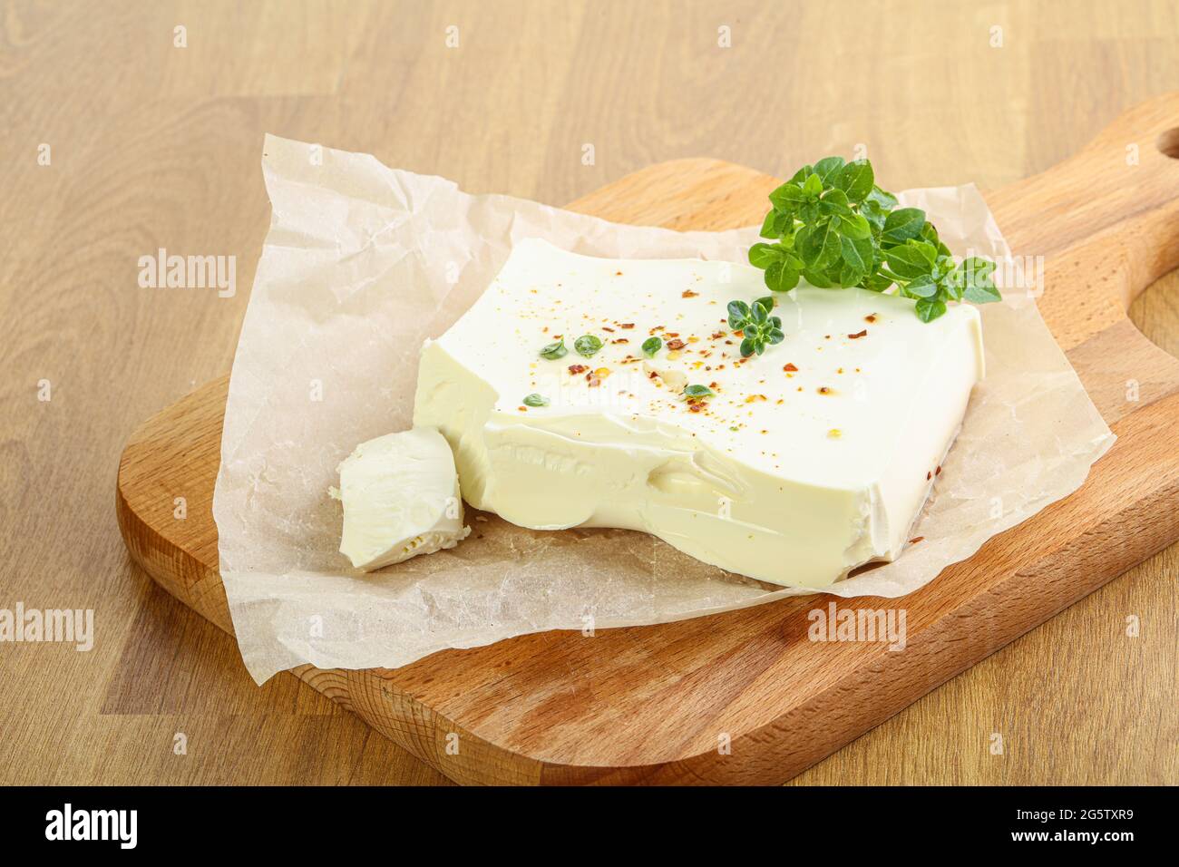 Greek Feta cheese over board served herbs Stock Photo - Alamy