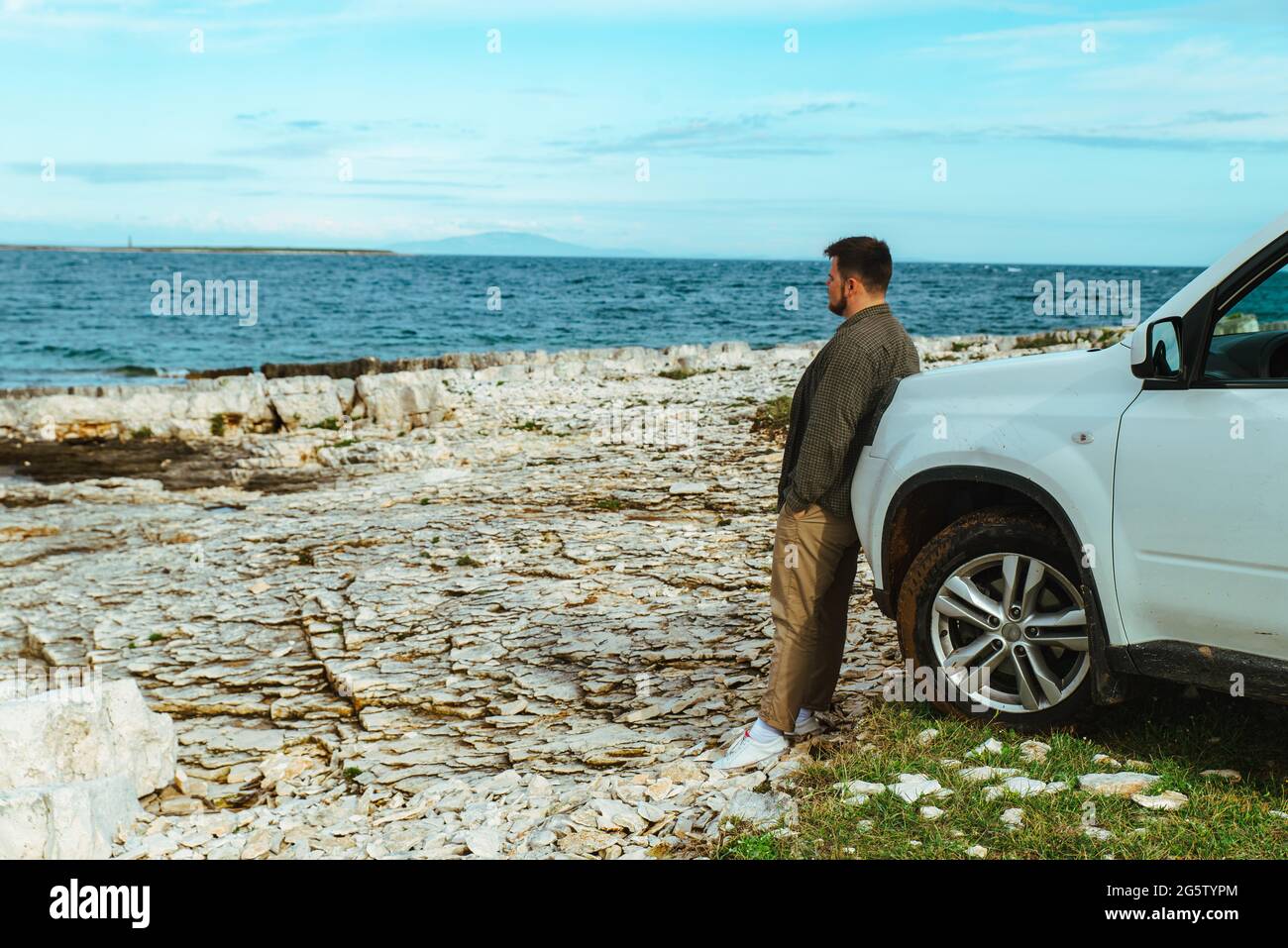 man standing near car at seaside. road trip concept. summer vacation ...